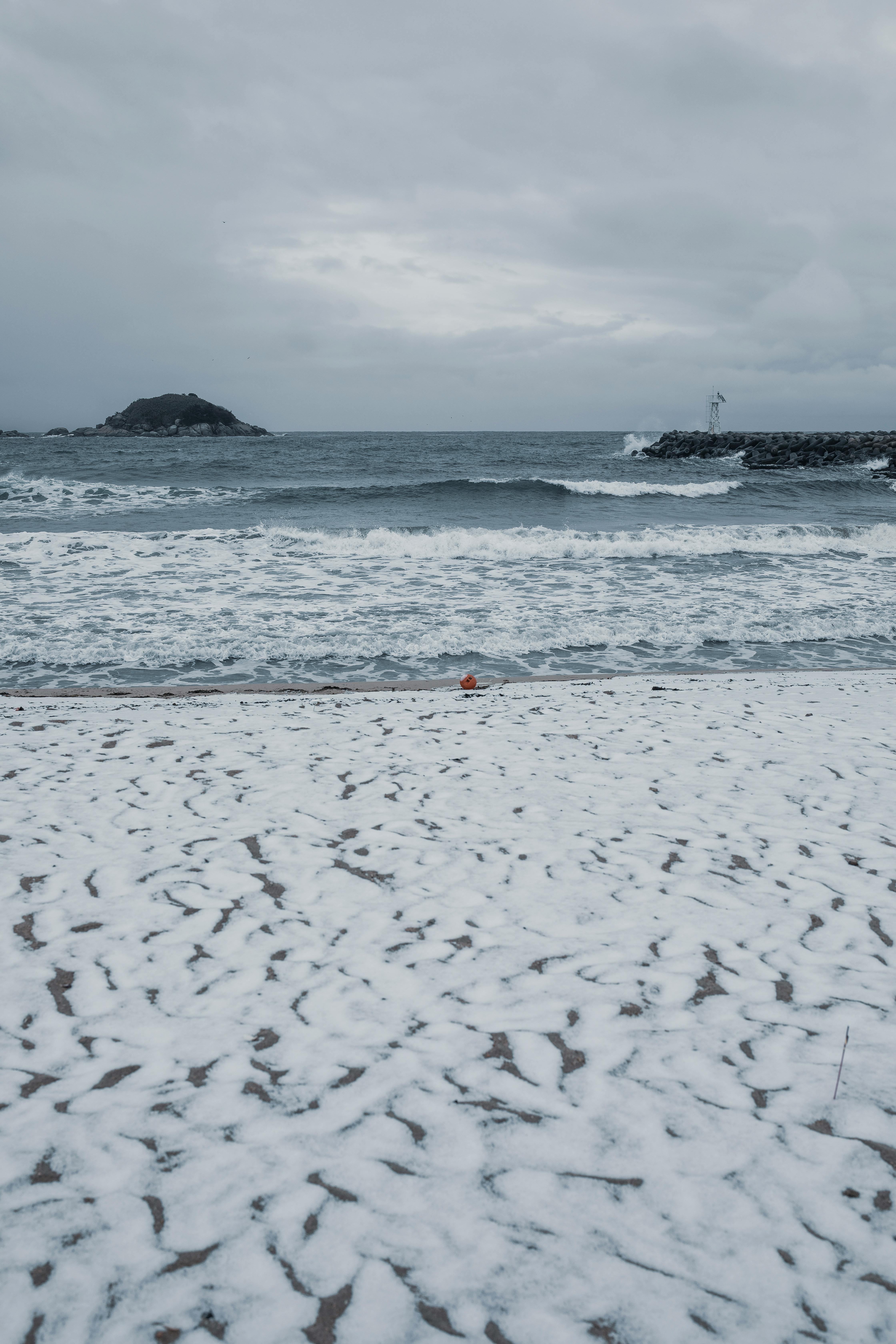 Snowy Beach Landscape with Calm Ocean Waves · Free Stock Photo