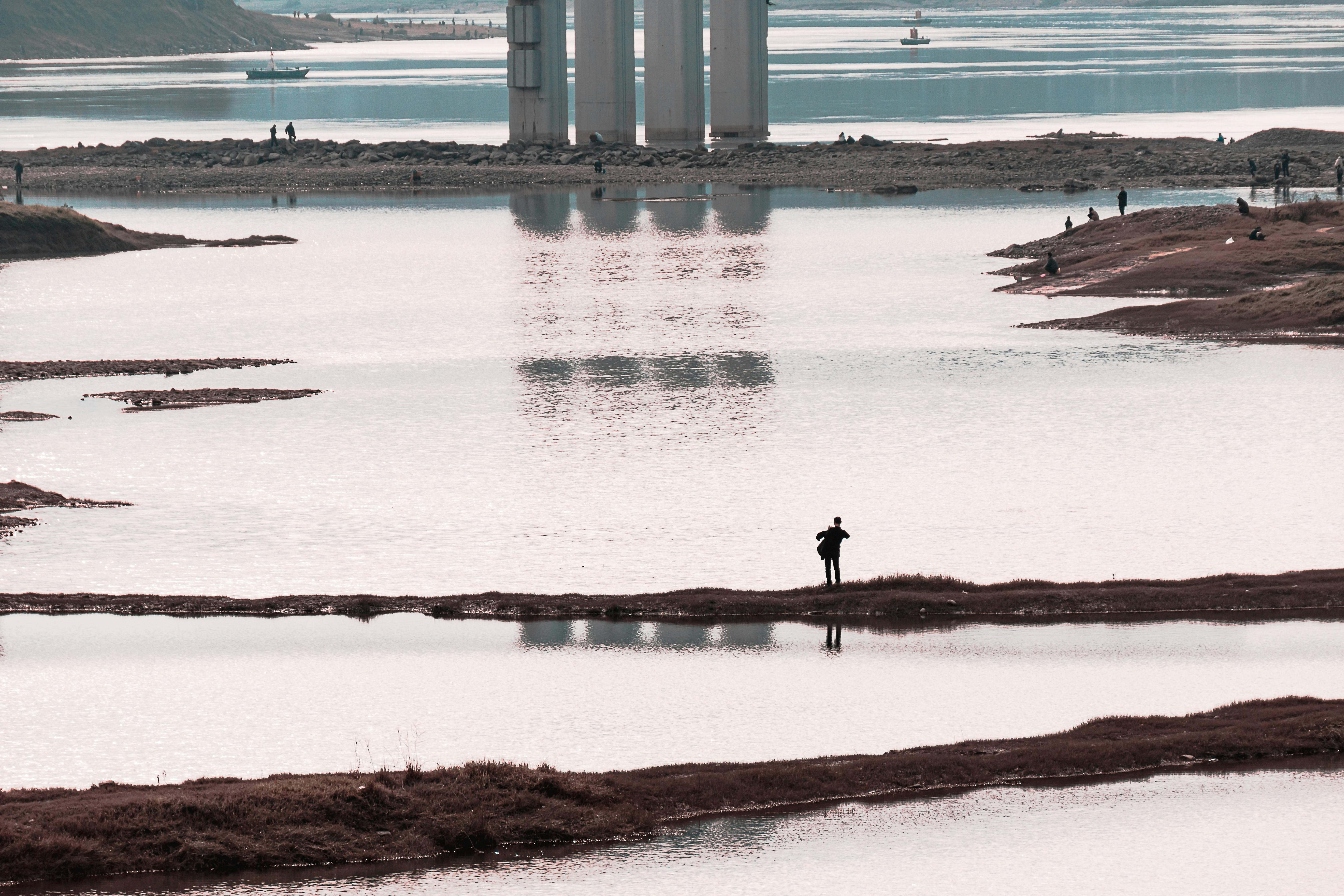 Calm River Scene with Bridge and Fisherman · Free Stock Photo