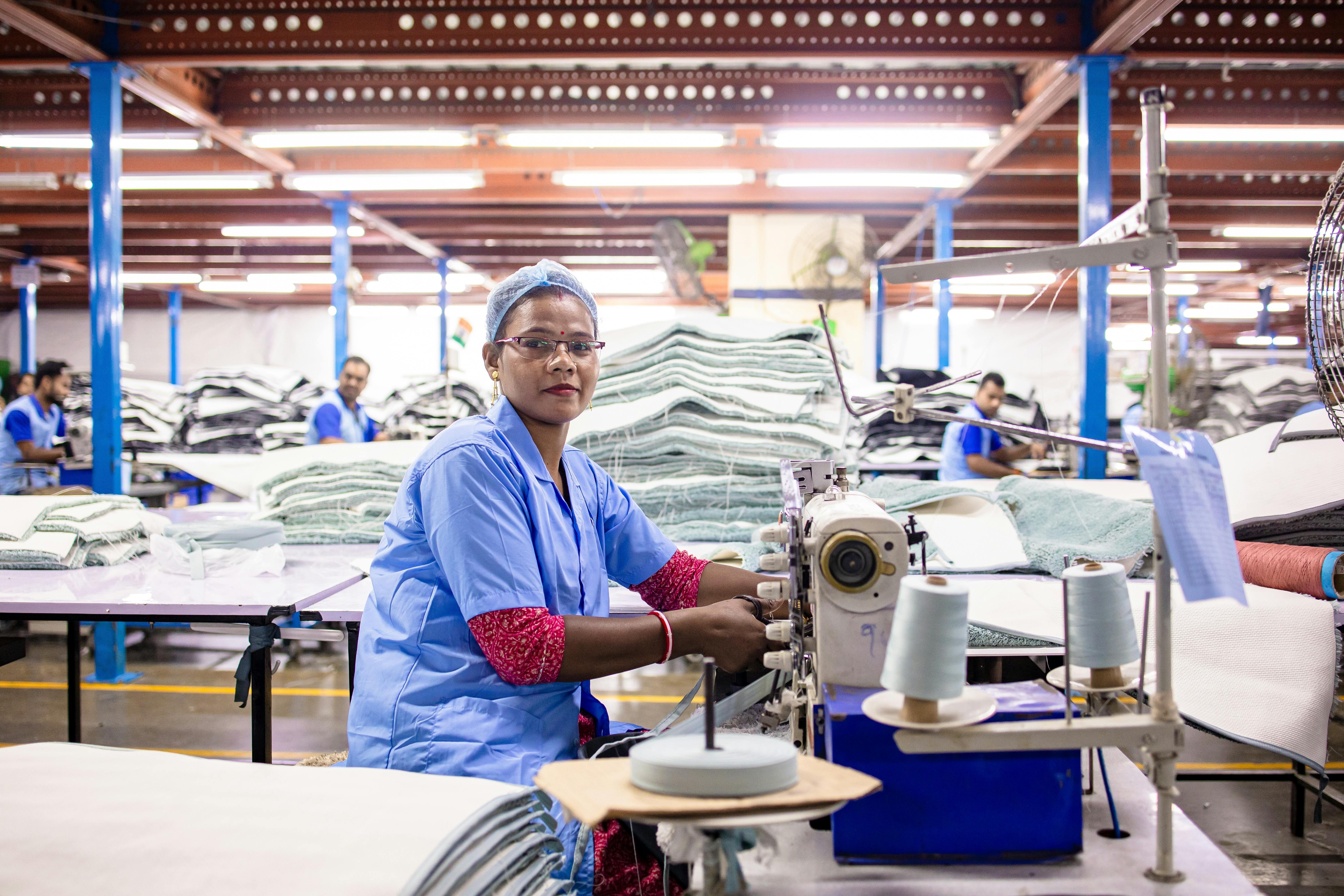 Female Textile Worker in Blue Uniform Operating Sewing Machine · Free ...