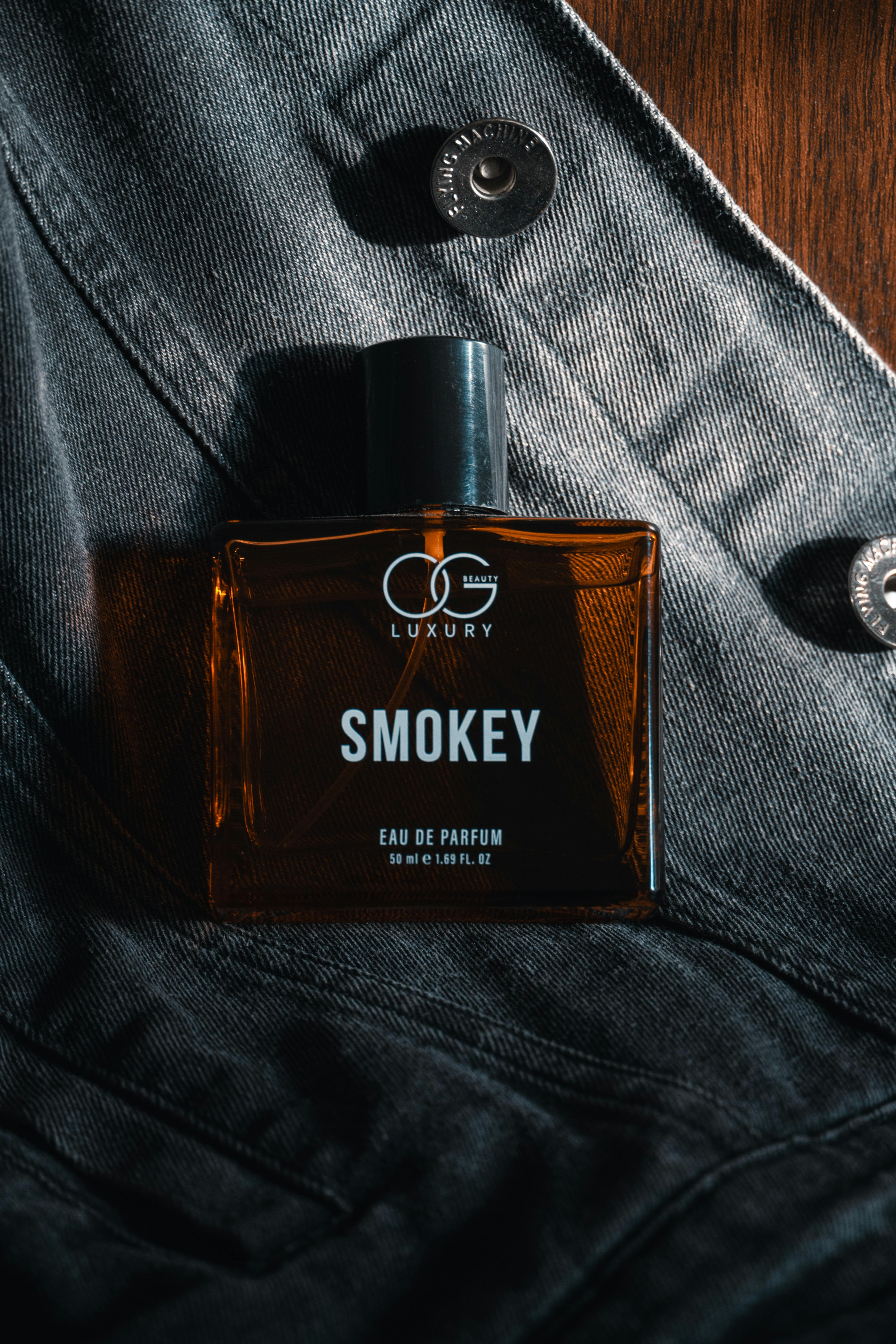 Elegant Smokey Perfume Bottle on Denim · Free Stock Photo