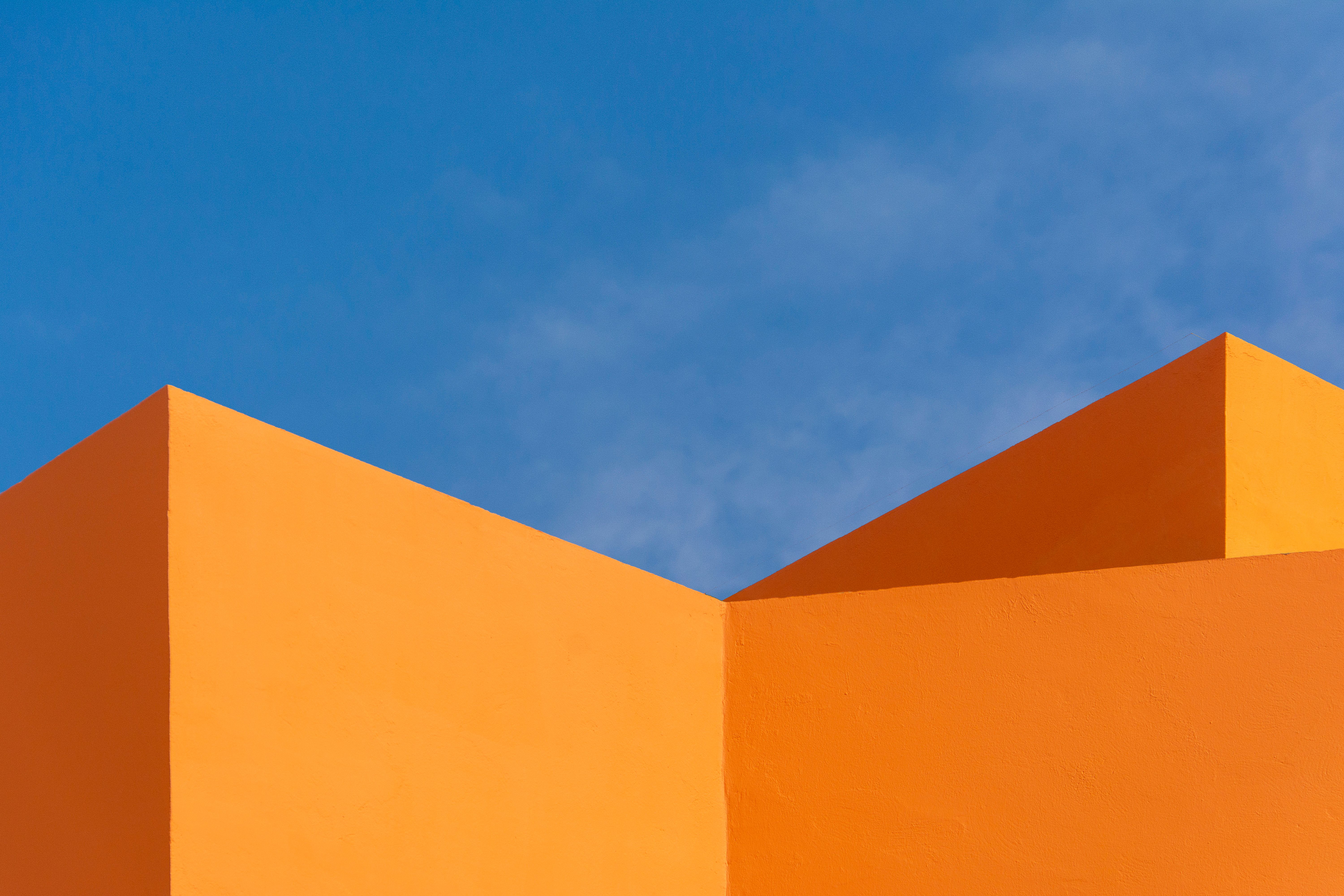 Vibrant Orange Building Against Blue Sky · Free Stock Photo