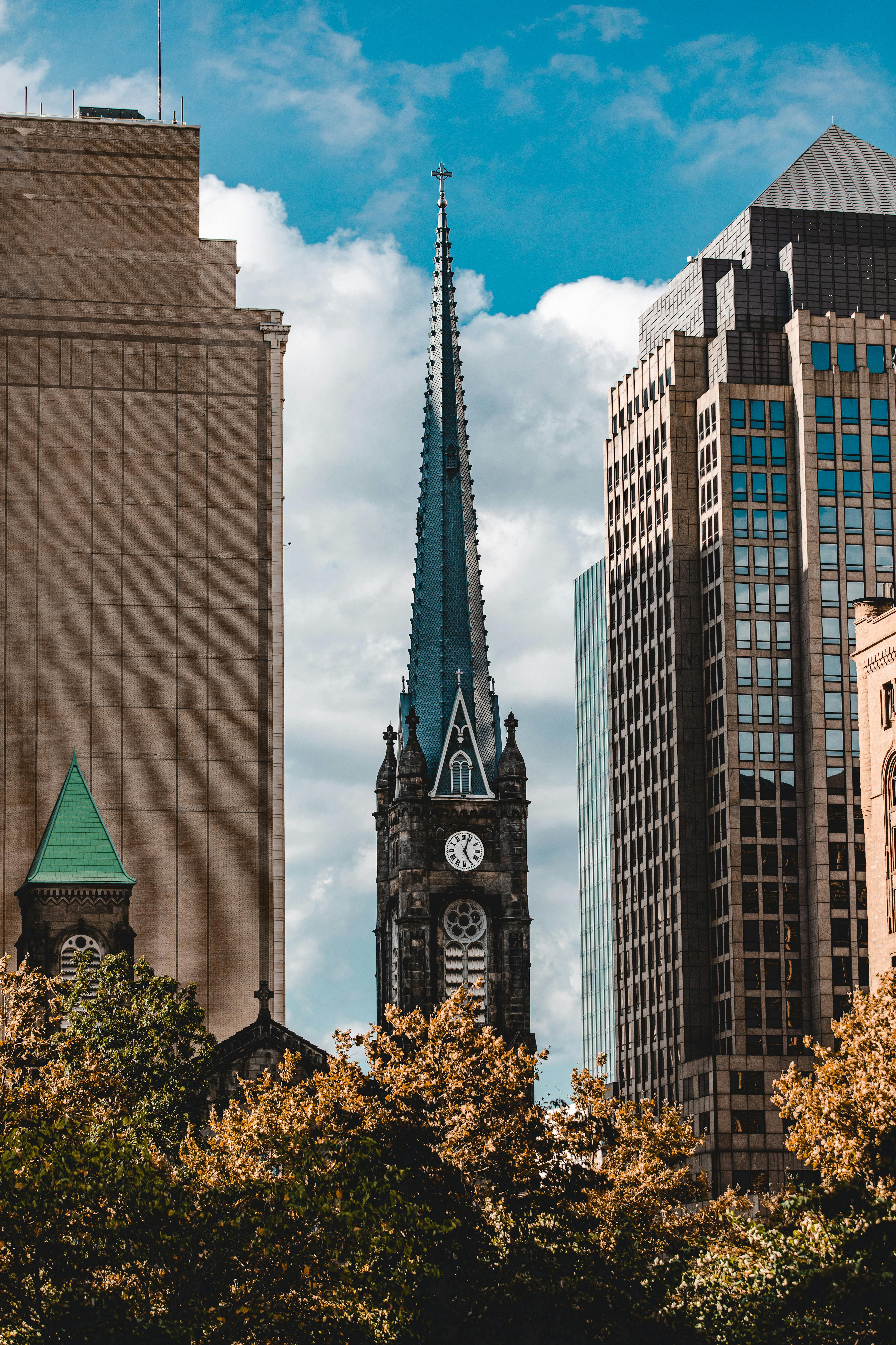 Old Gothic building among modern skyscrapers · Free Stock Photo