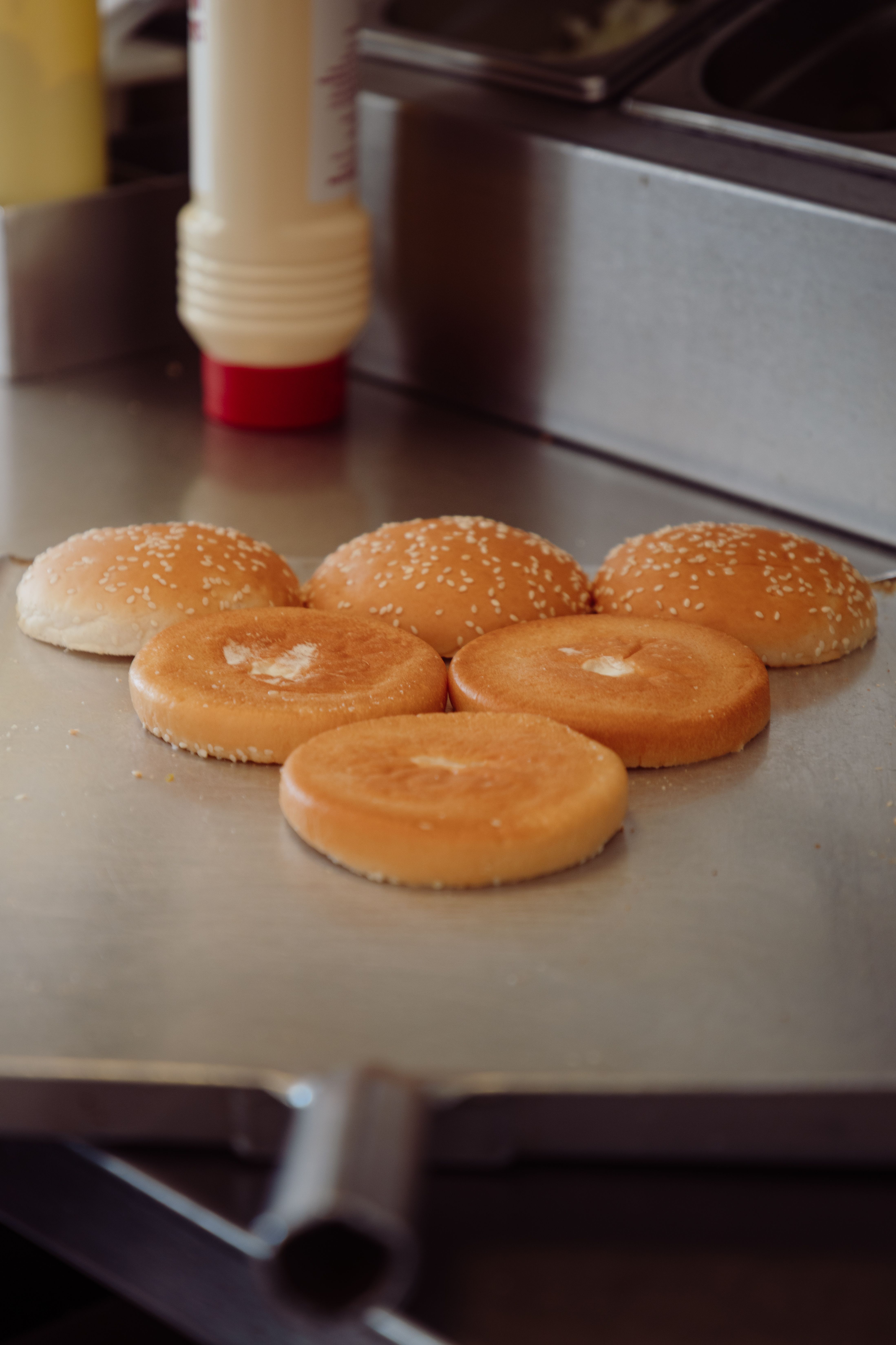 Sesame Burger Buns on Grill in Fast Food Kitchen · Free Stock Photo