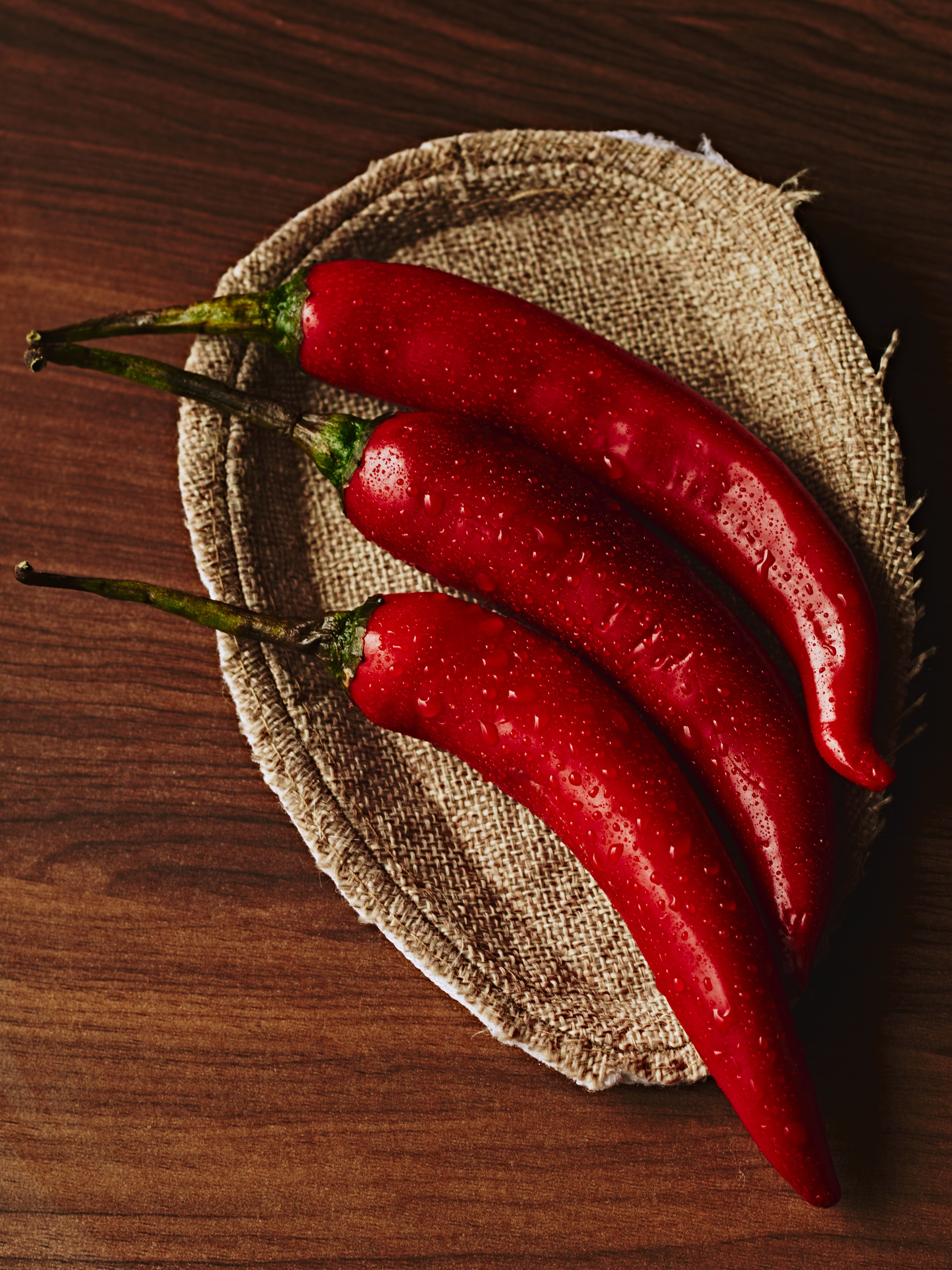 Fresh Red Chili Peppers on Rustic Fabric · Free Stock Photo