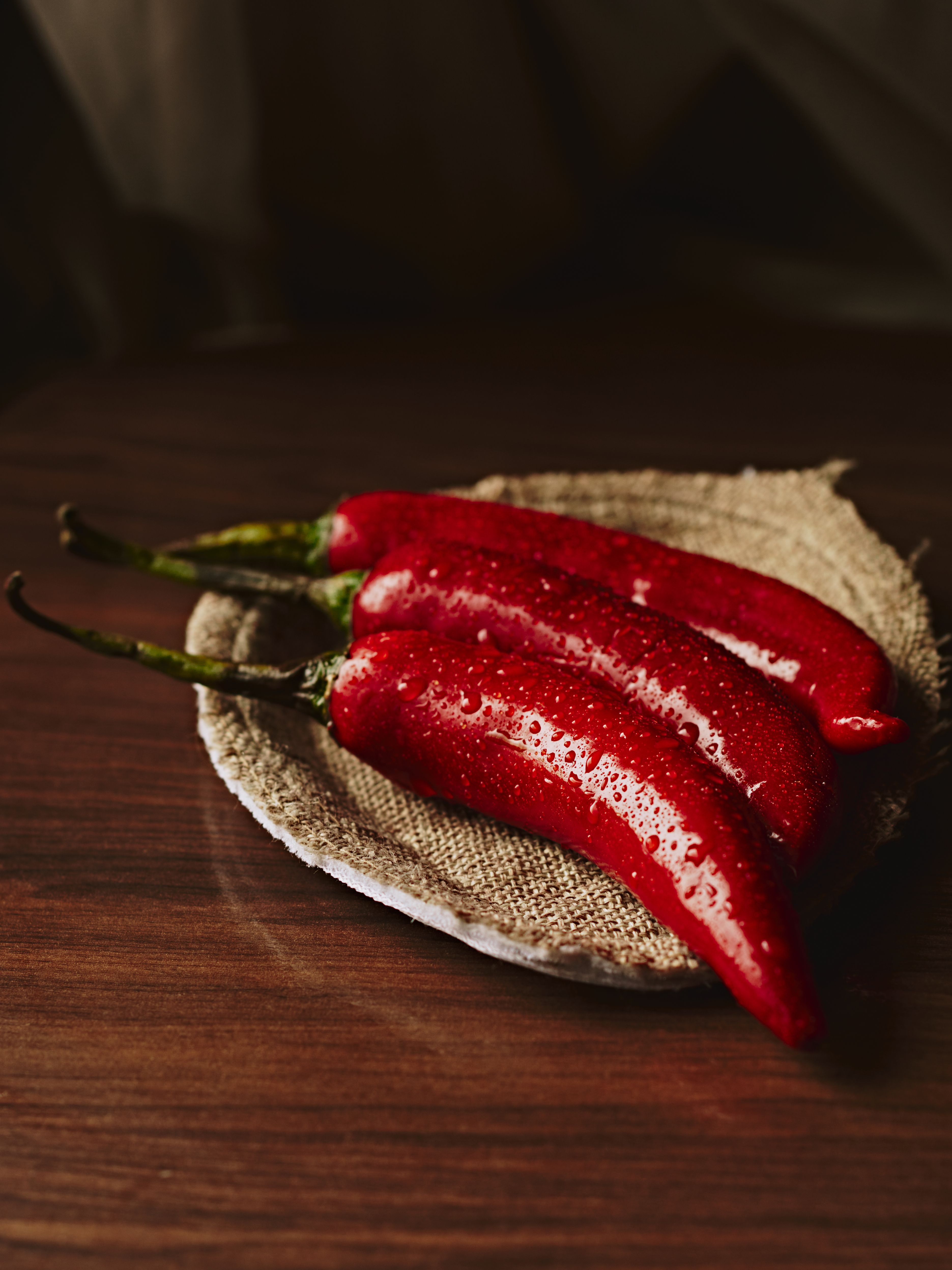 Fresh Red Chili Peppers on Rustic Fabric · Free Stock Photo