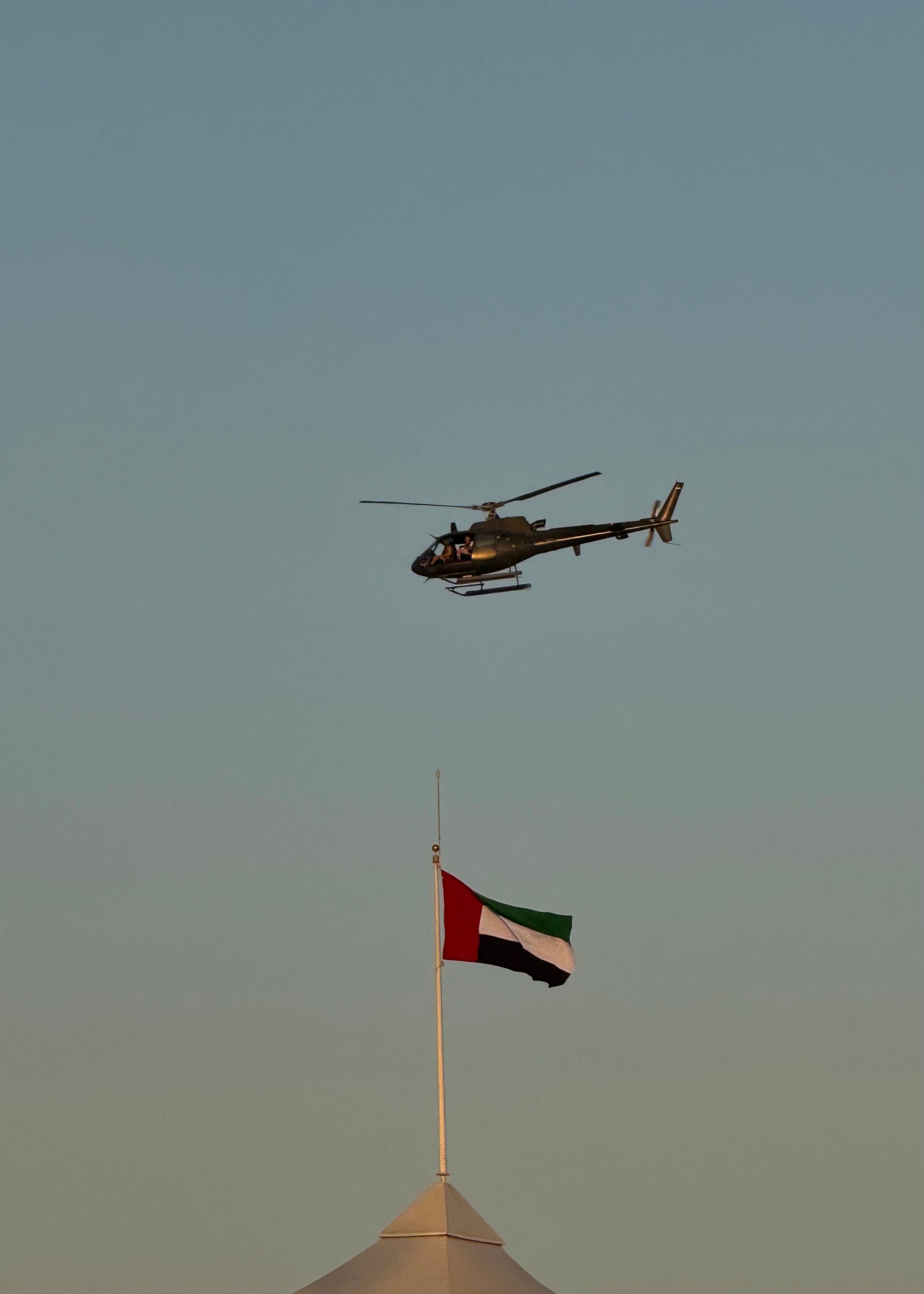 Military Helicopter Flying Over UAE Flag · Free Stock Photo