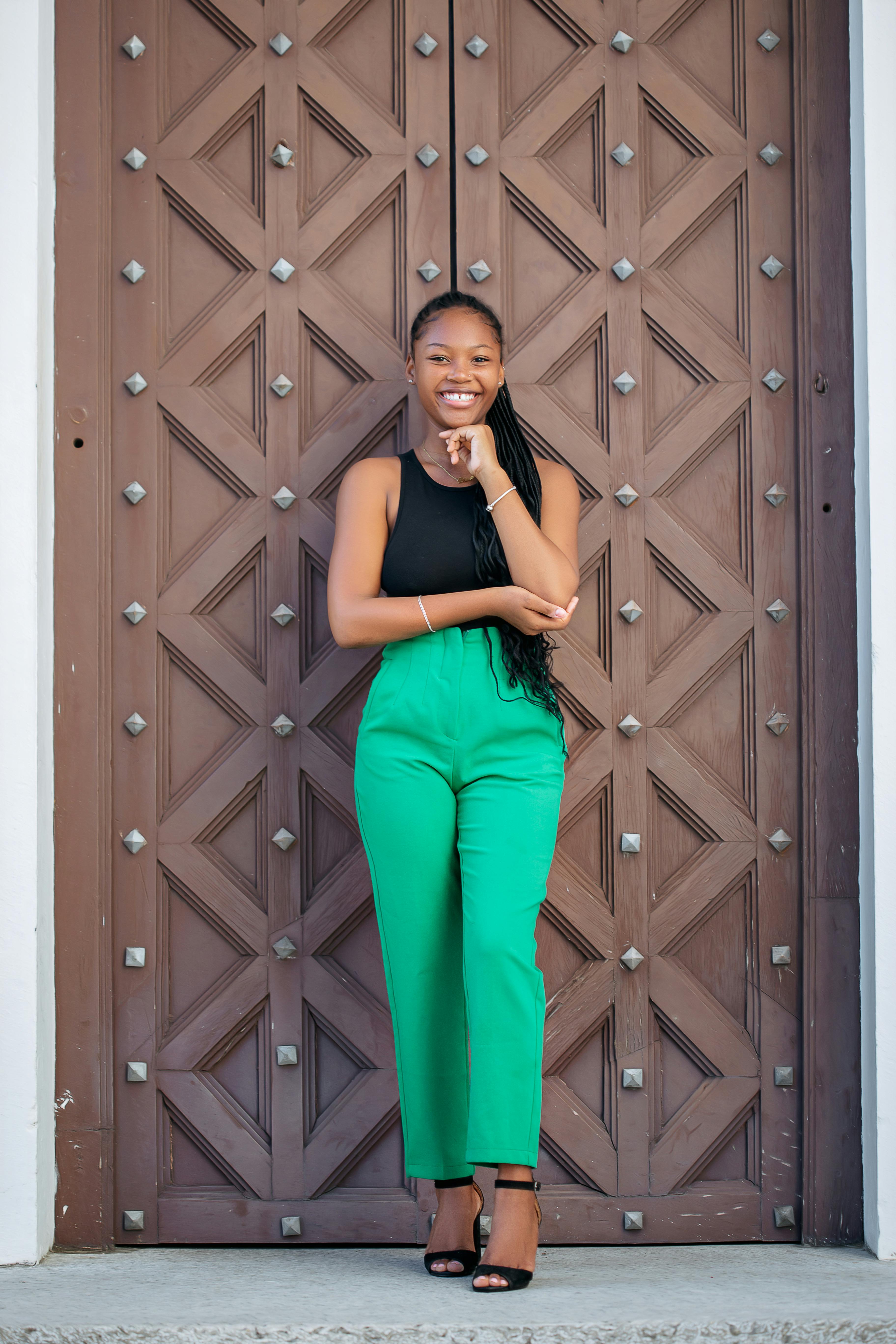 Stylish Woman Posing Against Wooden Door in Maputo · Free Stock Photo
