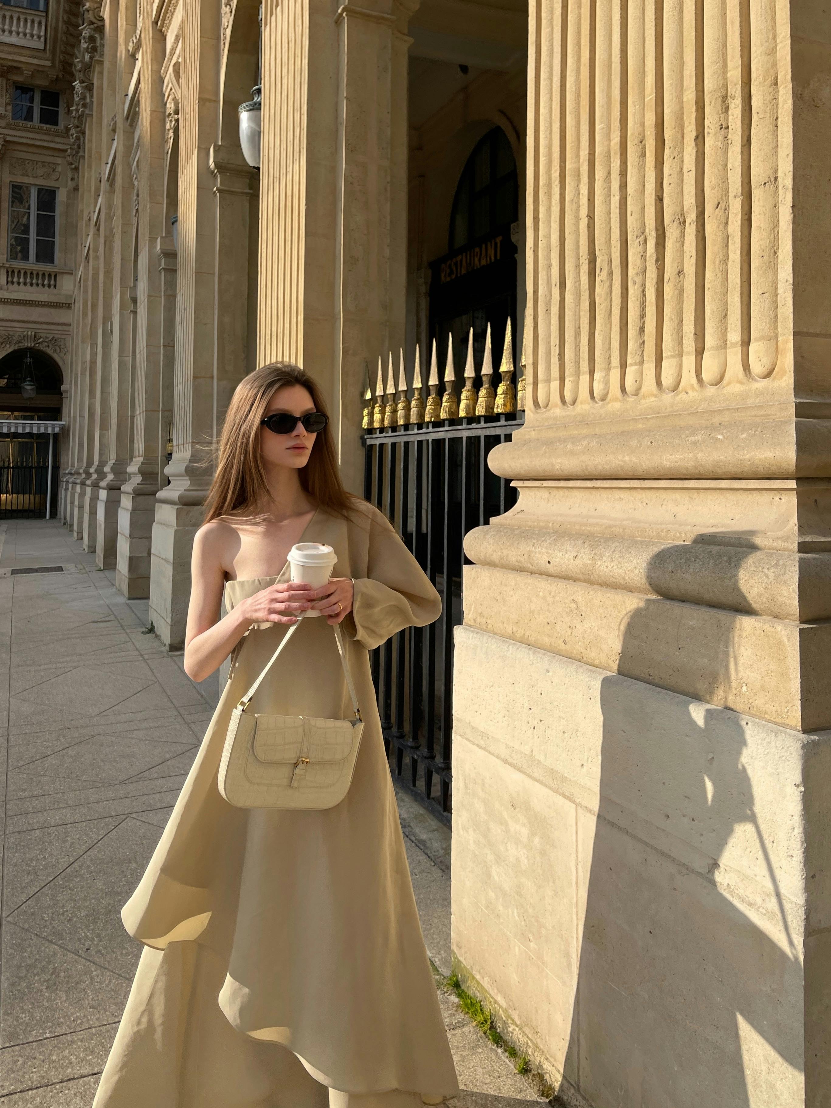 Elegant Woman in Beige Dress Walking Along Architectural Pathway · Free ...