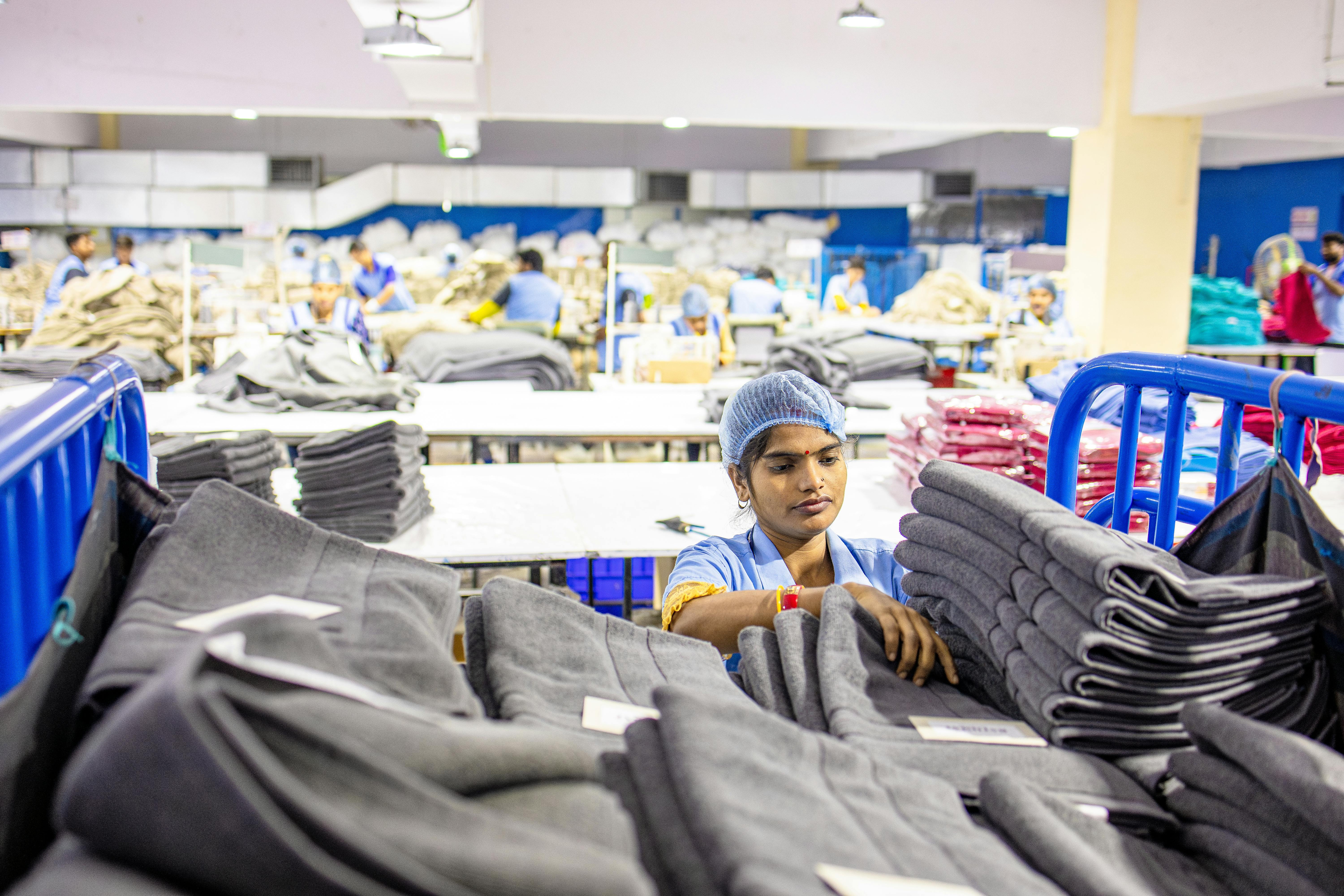 South Asian Textile Factory Worker Sorting Fabric · Free Stock Photo