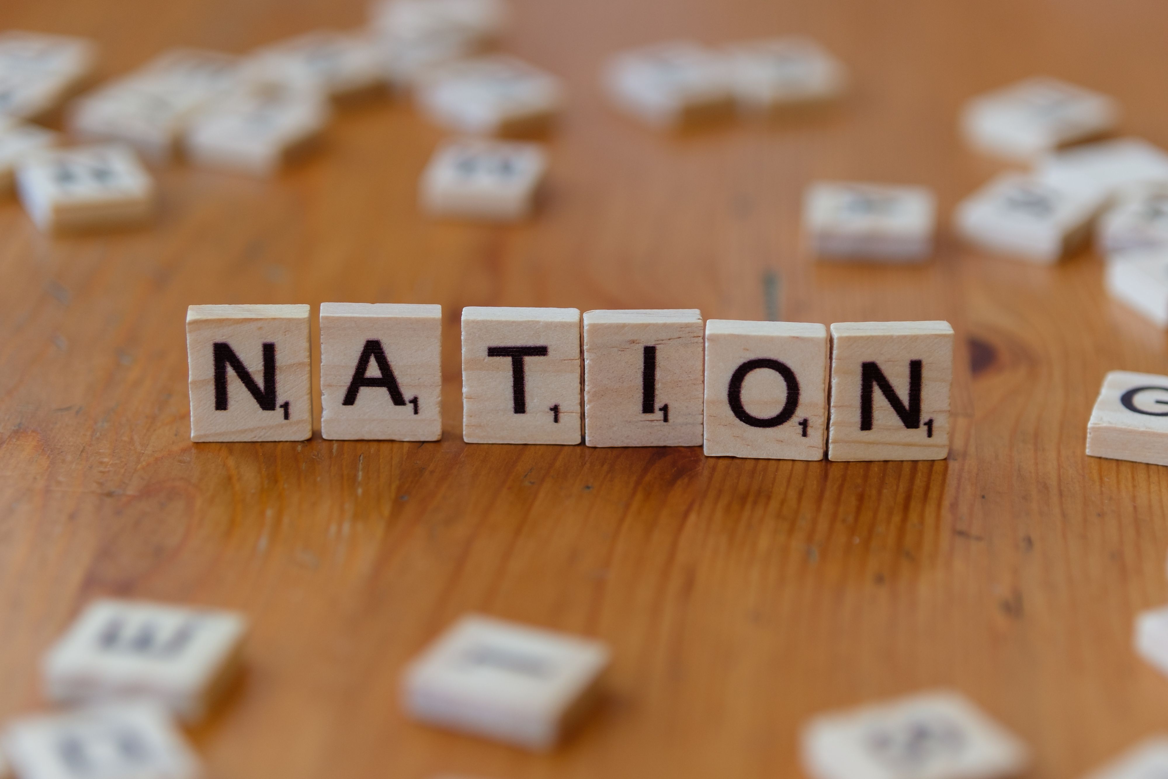 Scrabble Letters Spelling Nation on Wood Table · Free Stock Photo