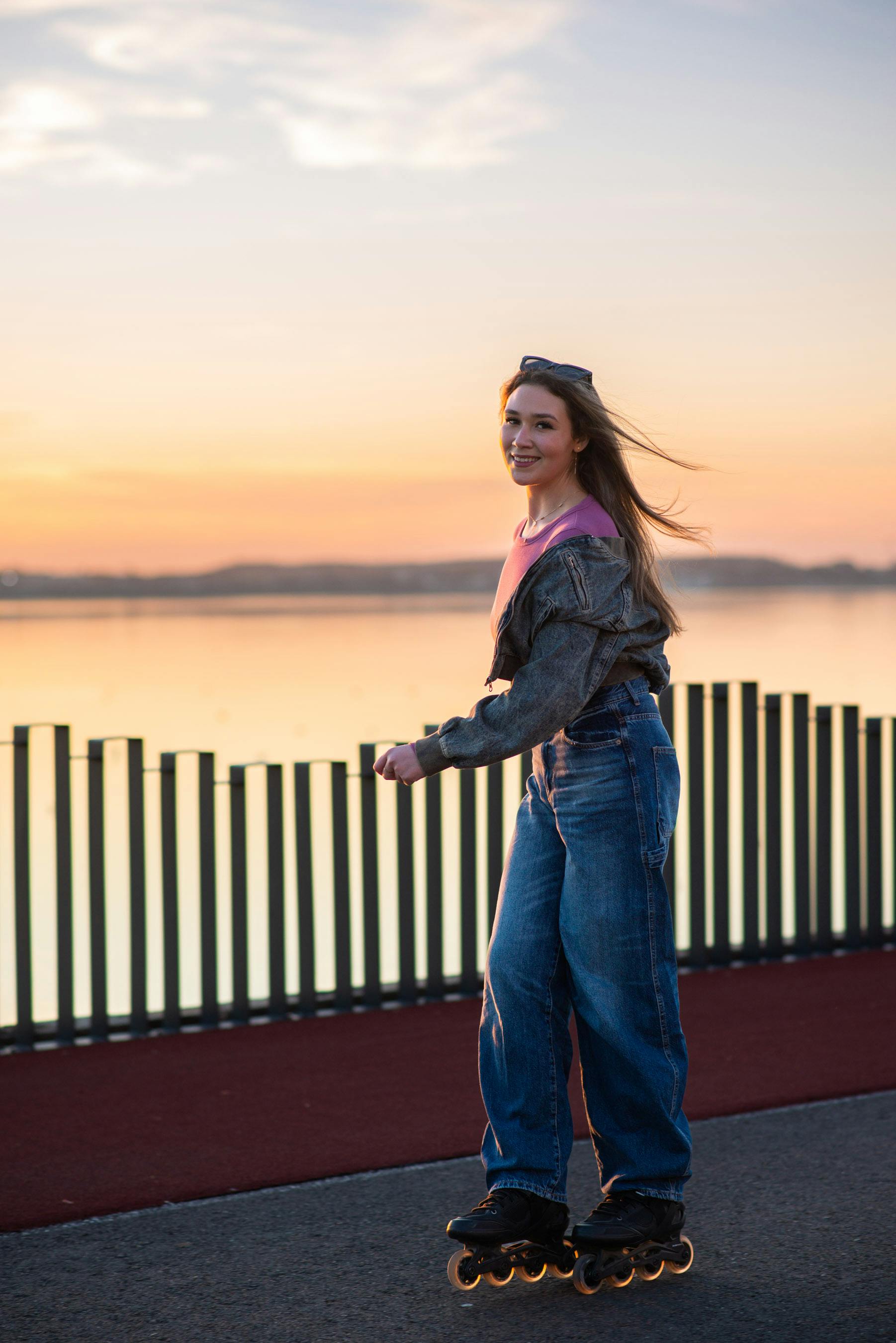 Young Woman Roller Skating at Sunset by Lake · Free Stock Photo