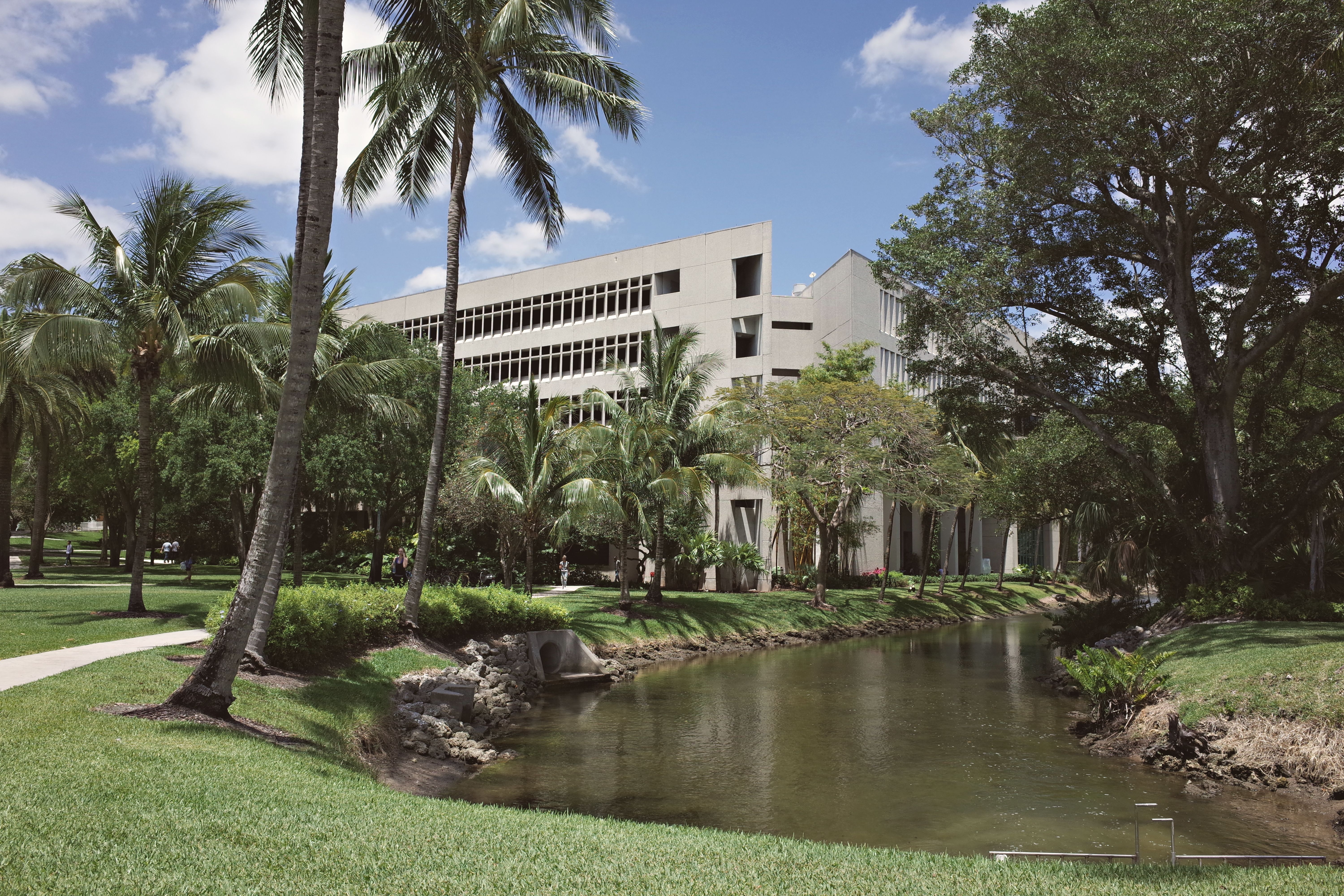 University Campus with Lush Greenery and Canal · Free Stock Photo