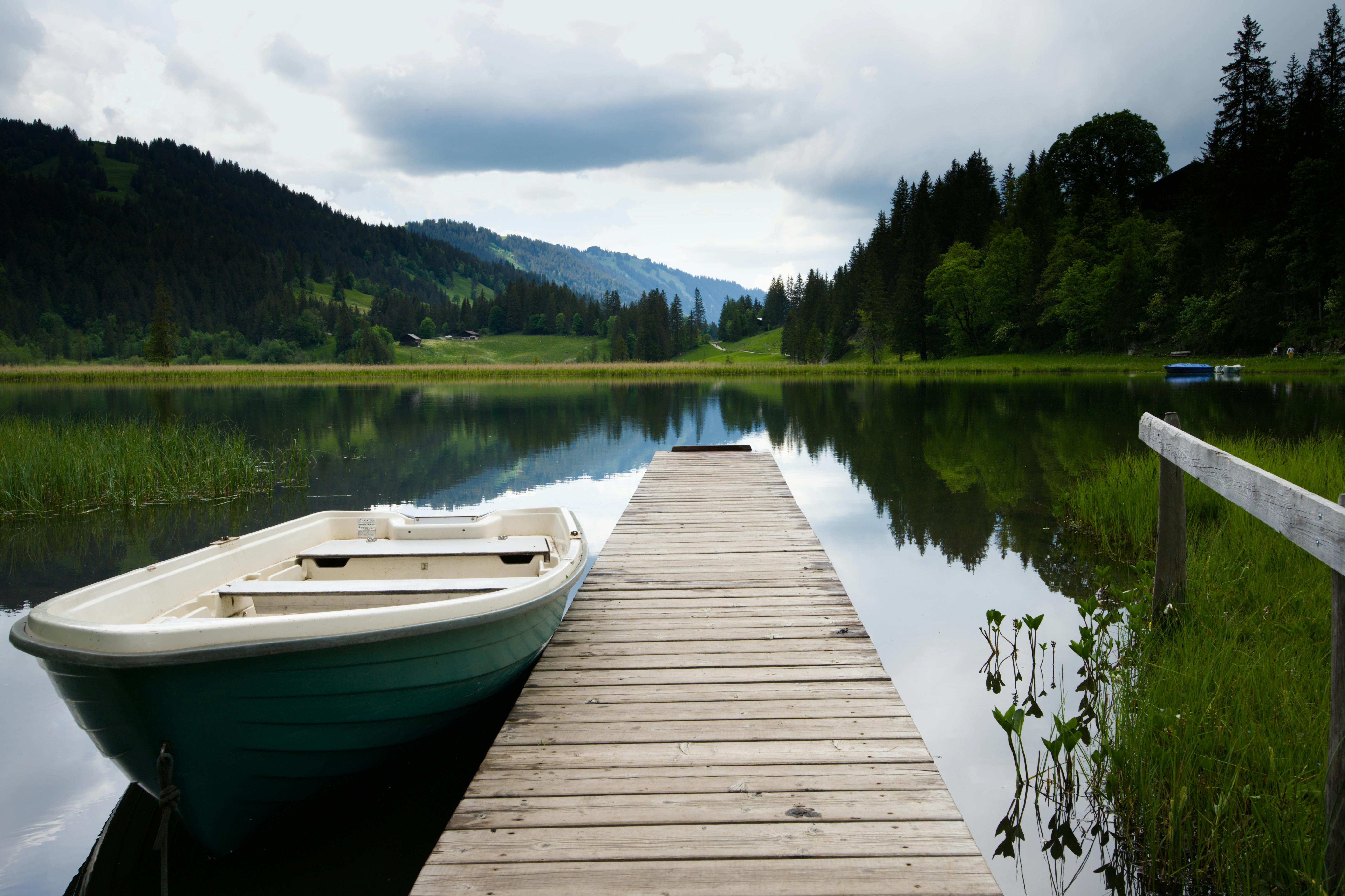 Serene Alpine Lake with Dock and Rowboat · Free Stock Photo