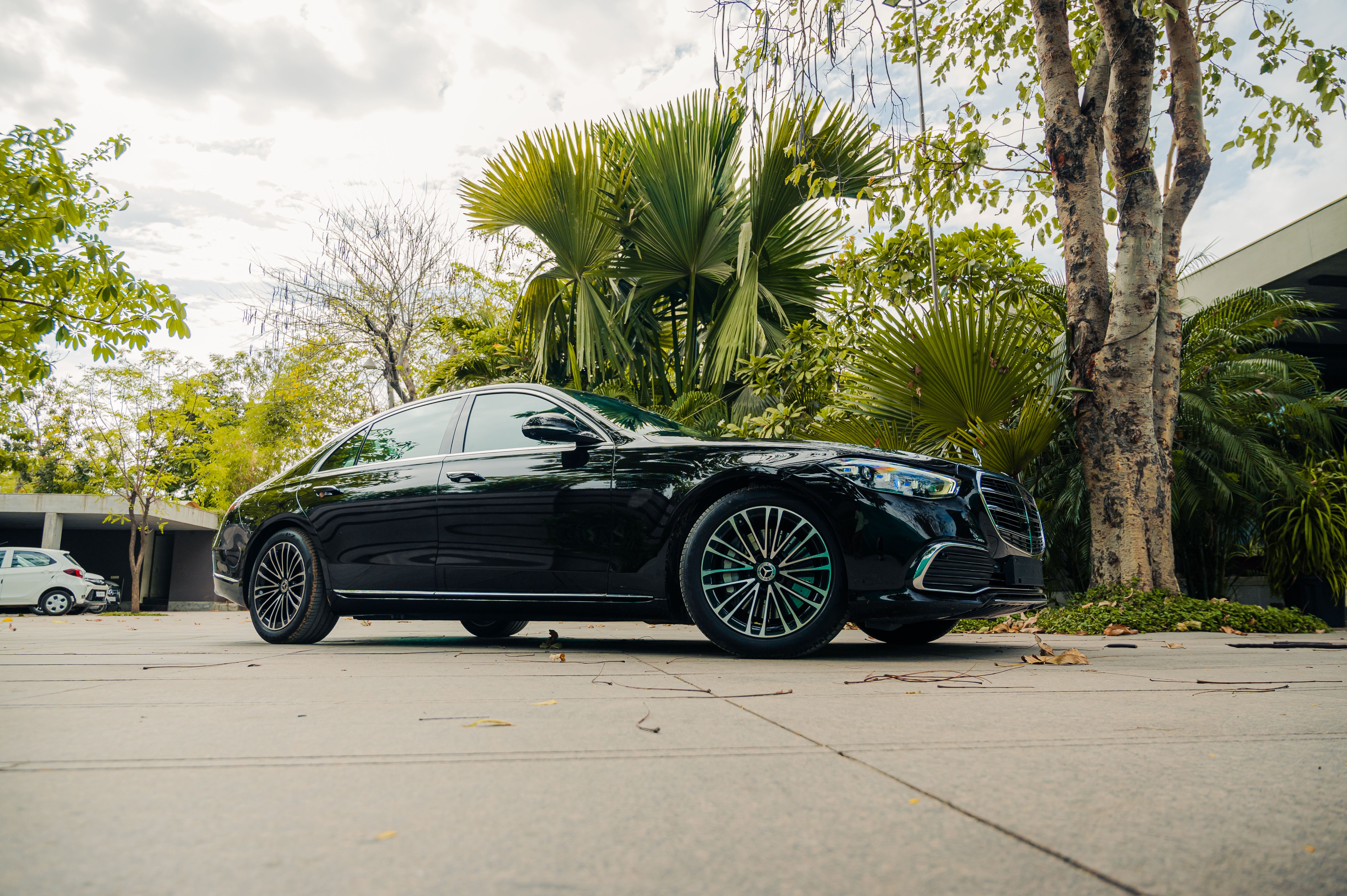 Elegant Black Luxury Car in Tropical Setting · Free Stock Photo