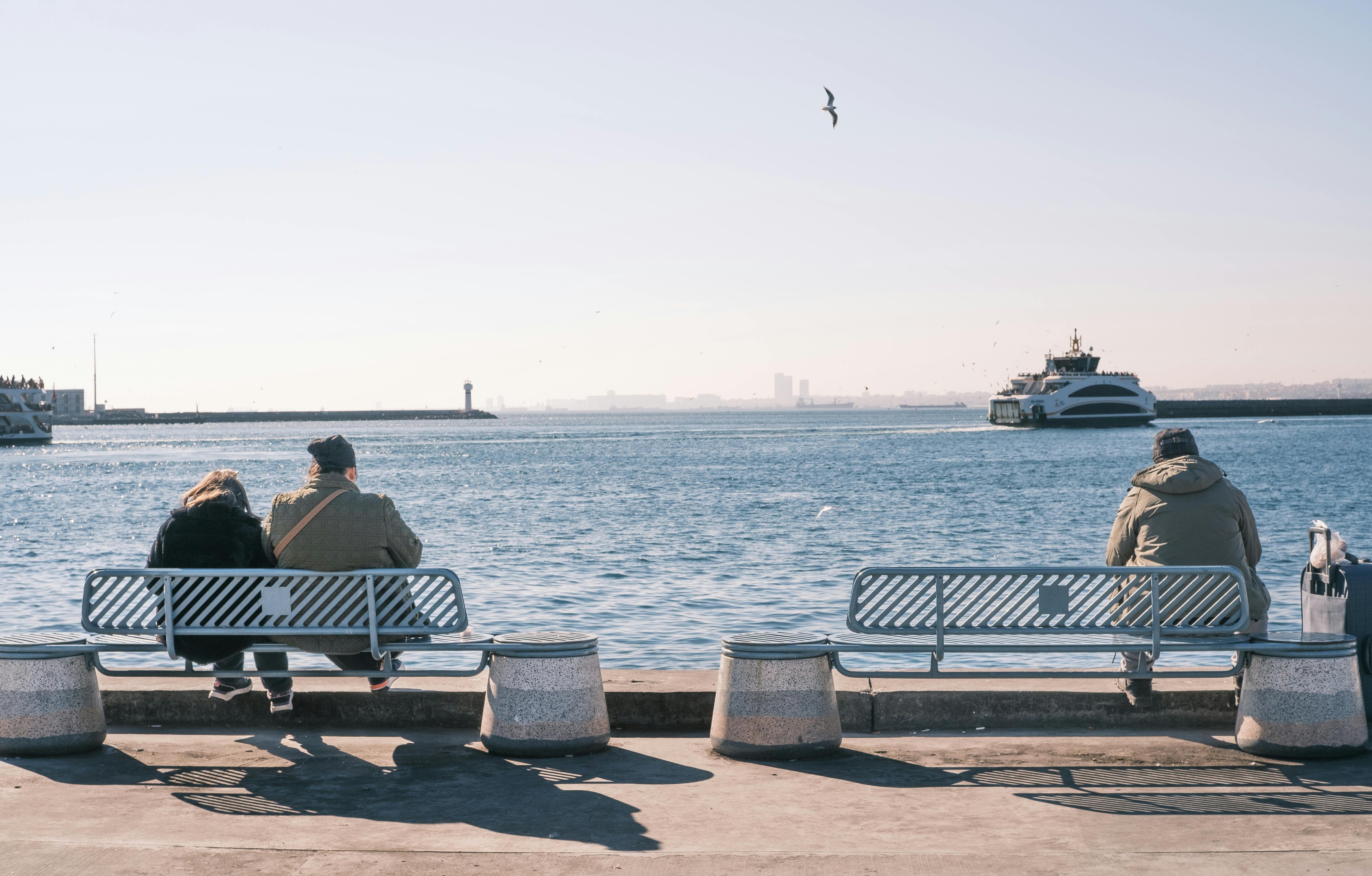 Peaceful Waterfront Seating with Ferry View · Free Stock Photo