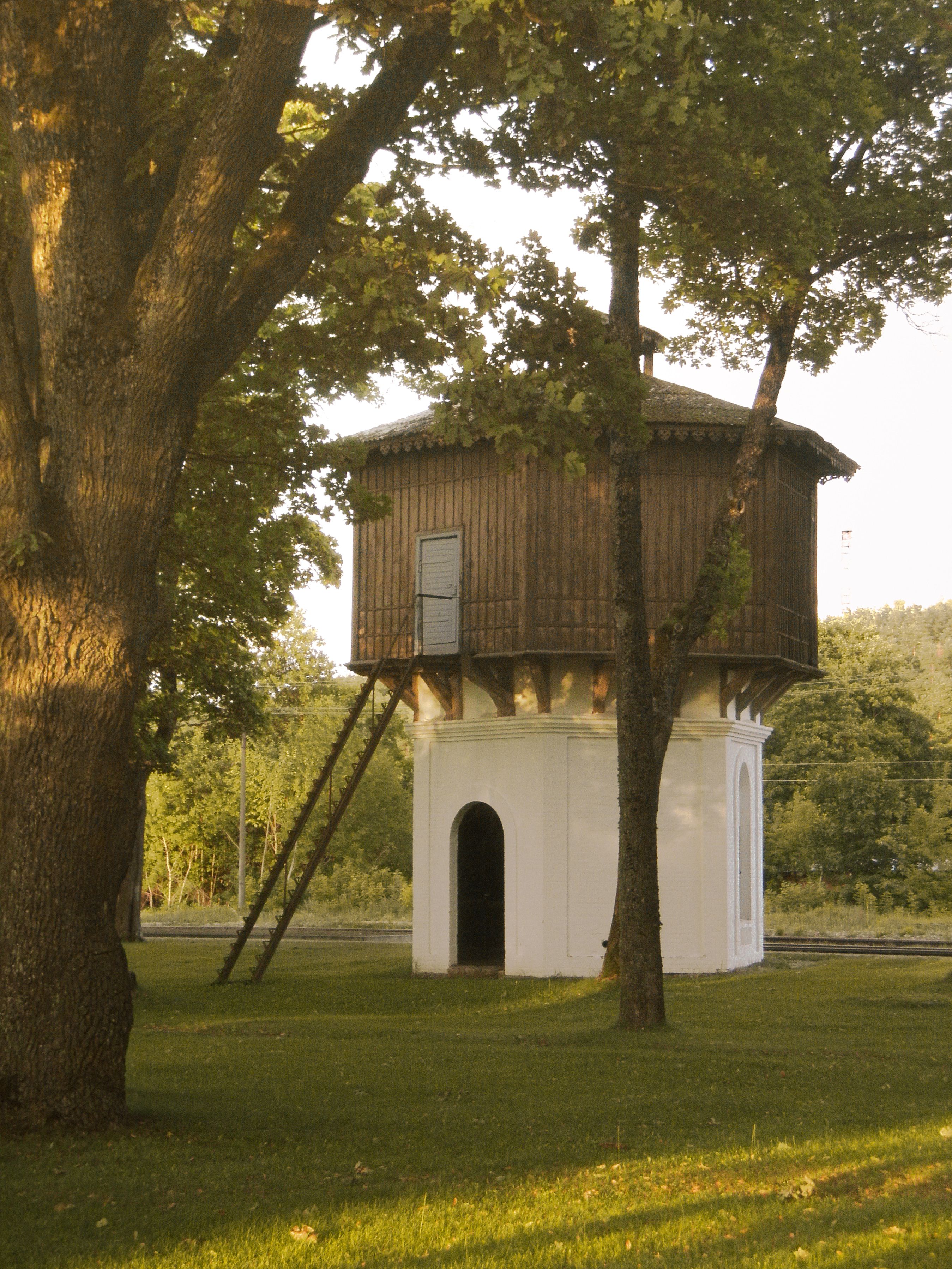 Historic Wooden Water Tower in Serene Park Setting · Free Stock Photo