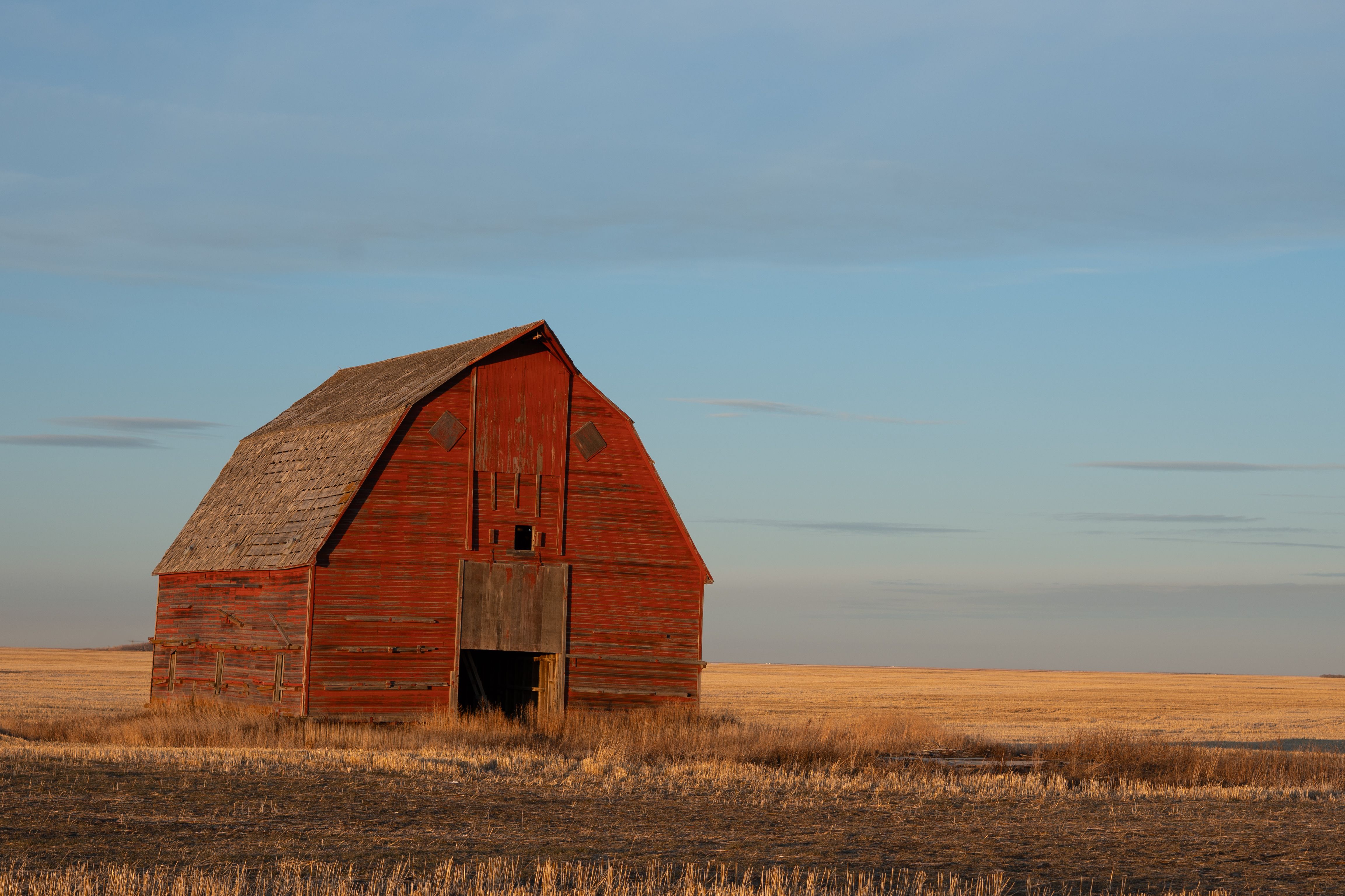 Rustic Red Barn in Open Farmland at Sunset · Free Stock Photo