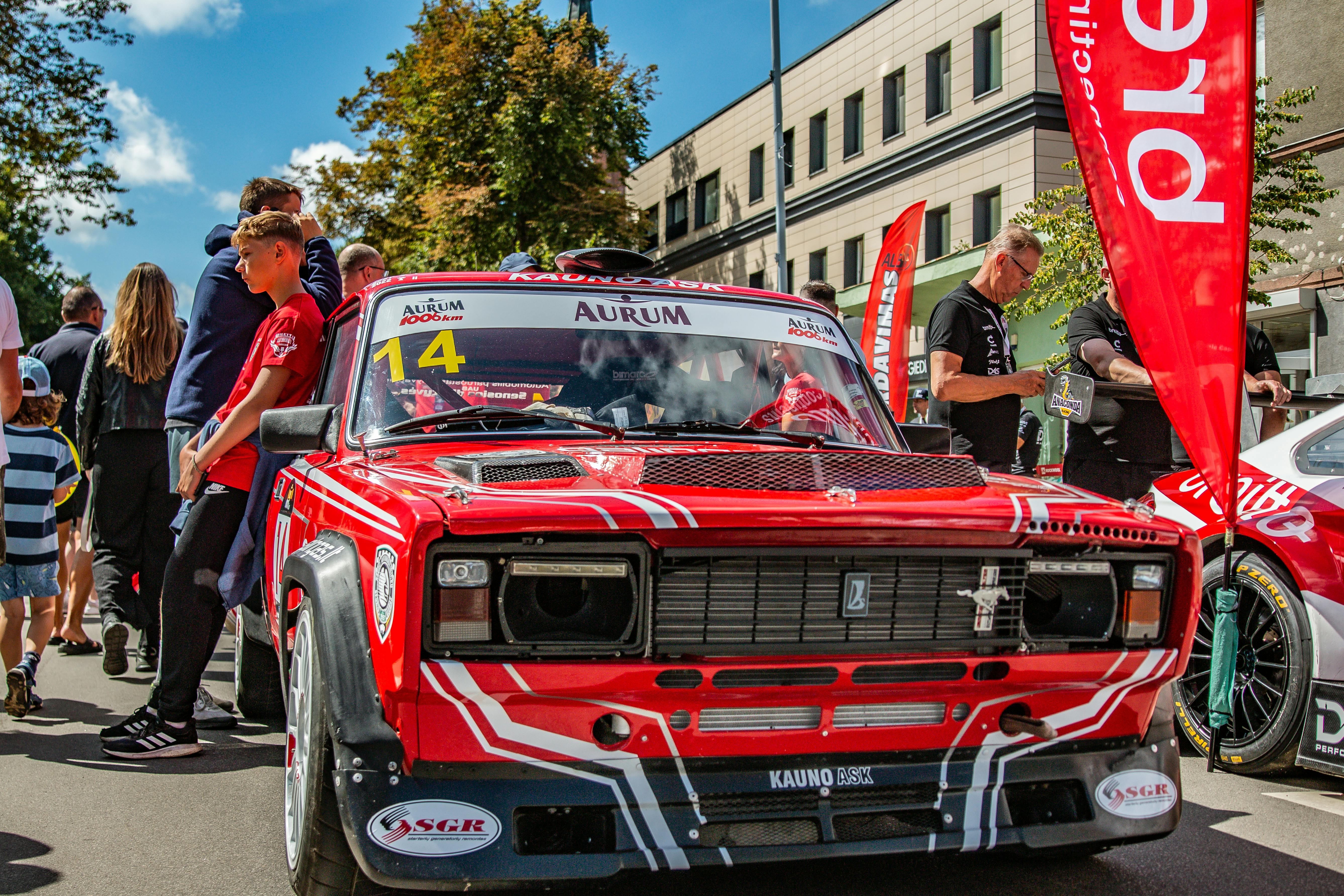 Vibrant Racing Event with Classic Red Car · Free Stock Photo