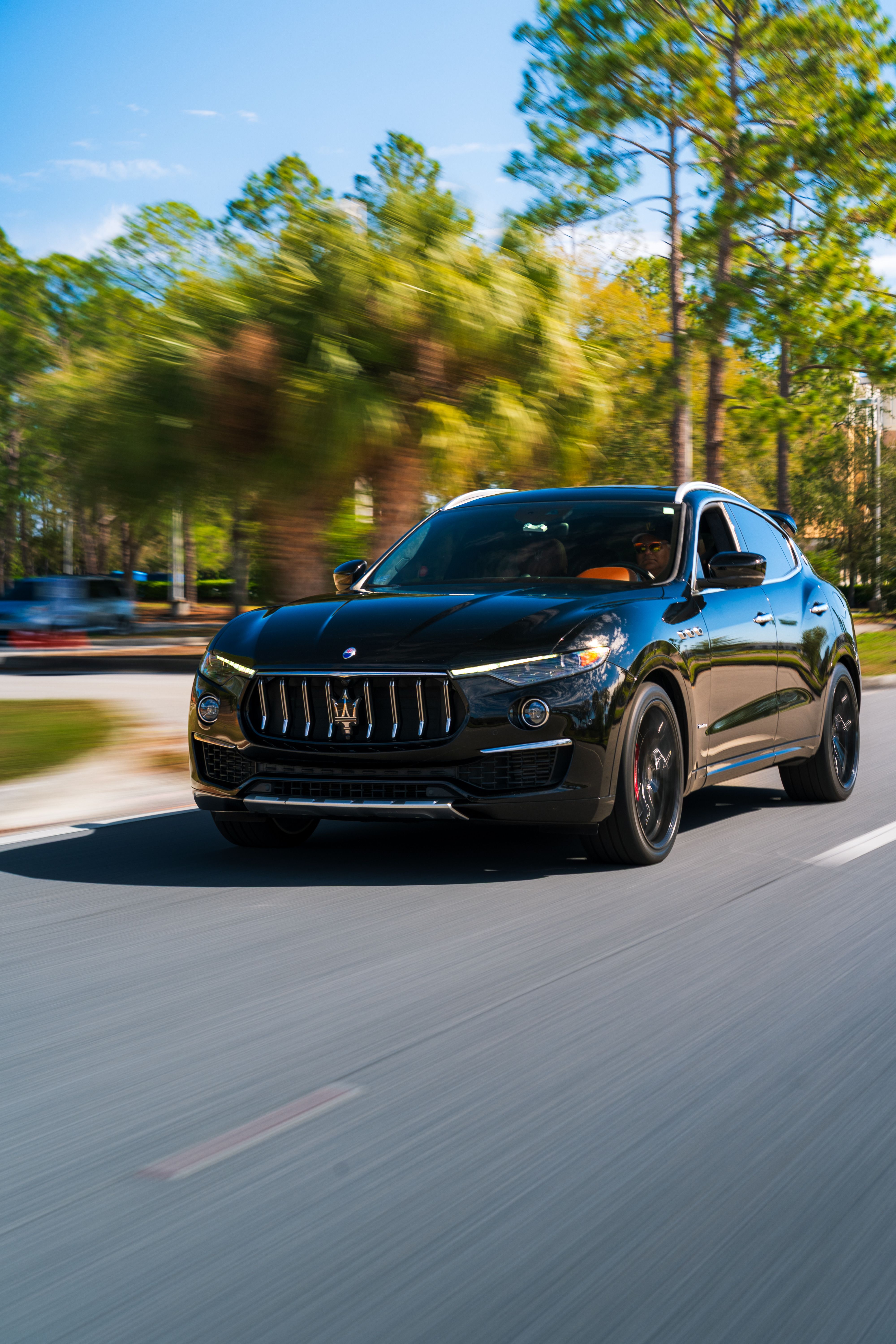 Luxury Black SUV Driving on a Sunny Day · Free Stock Photo