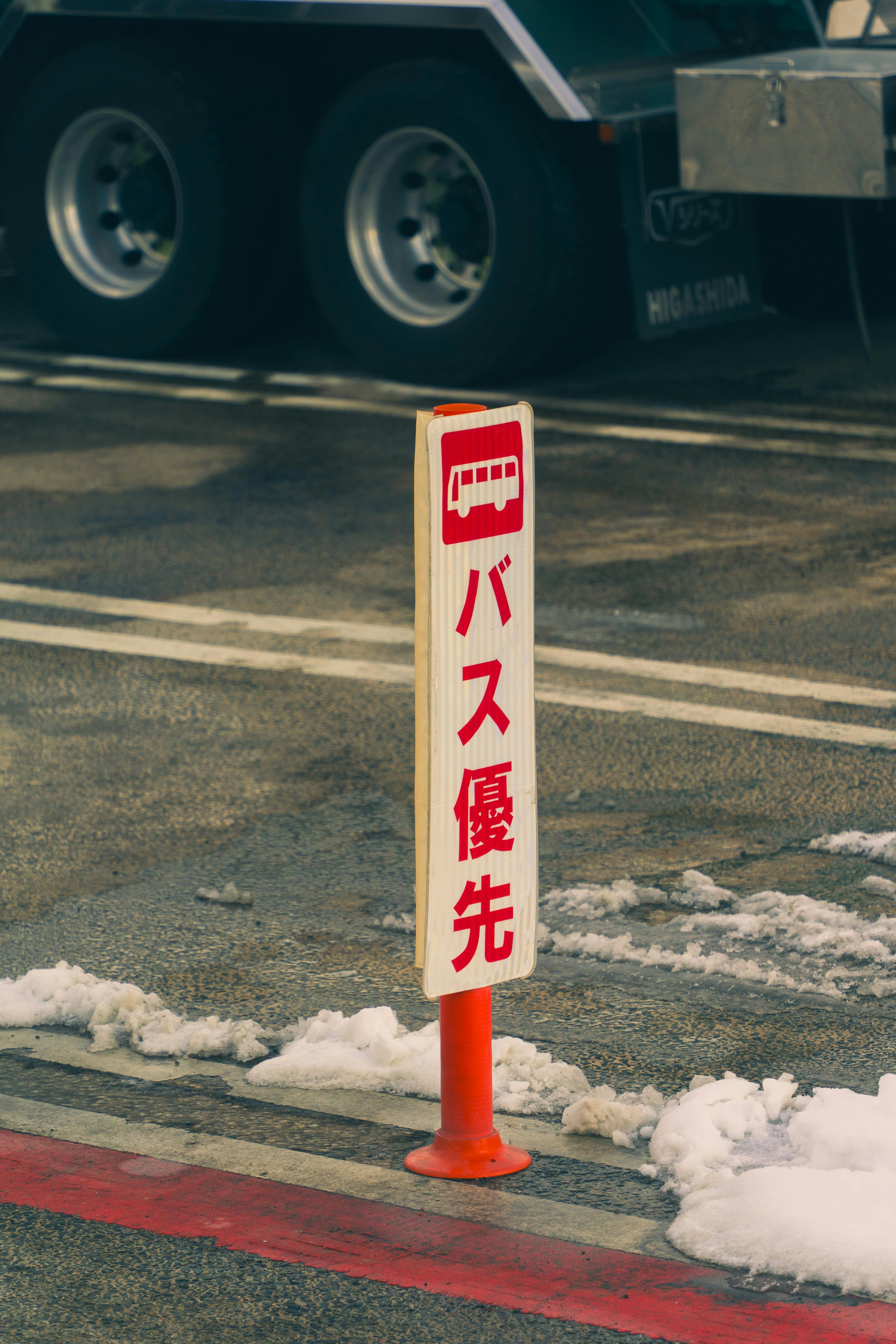 Japanese Bus Stop Sign in Snowy Urban Scene · Free Stock Photo
