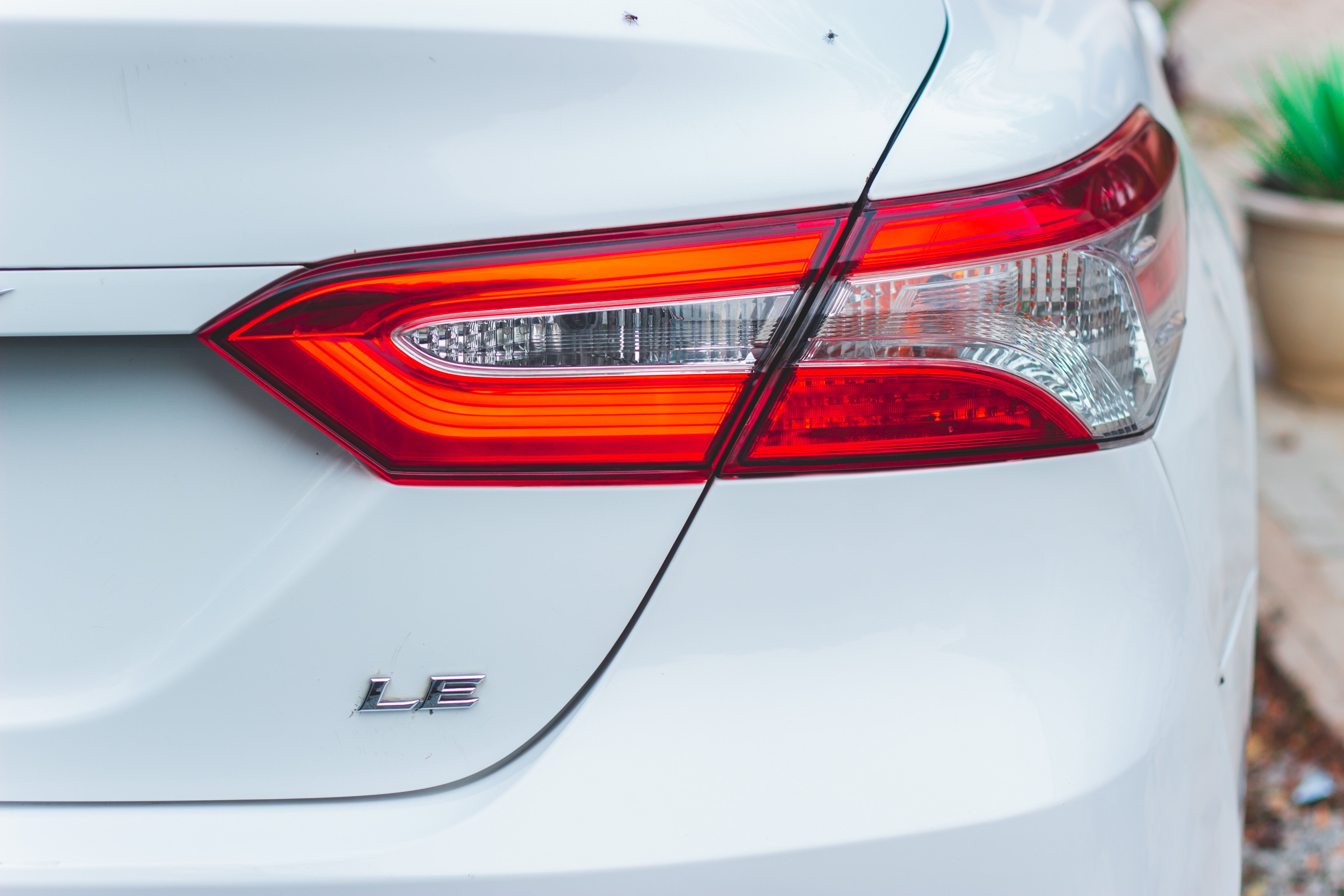 Sleek White Car Tail Light and Emblem Close-Up · Free Stock Photo
