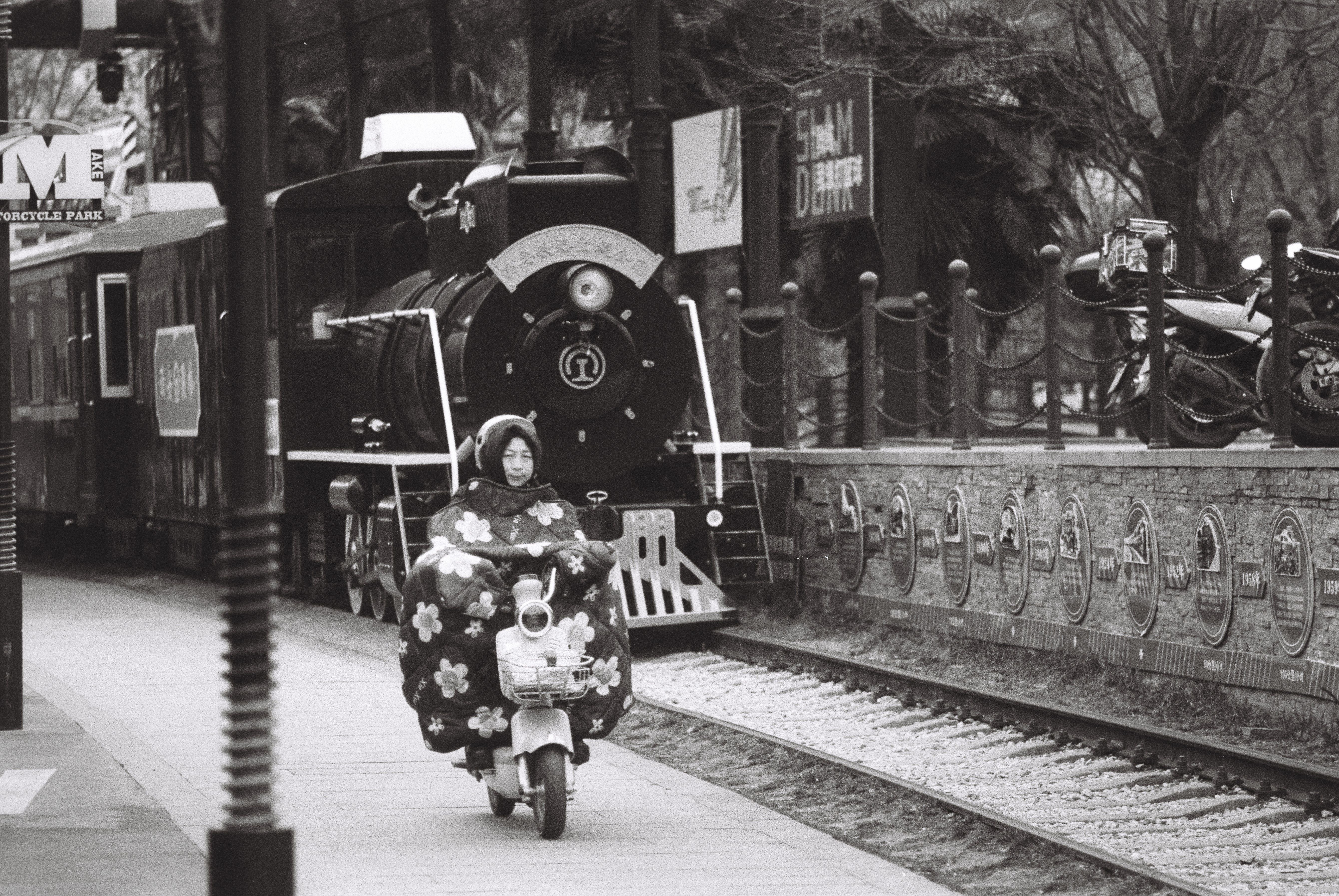Vintage Train and Scooter Rider in Urban Setting · Free Stock Photo