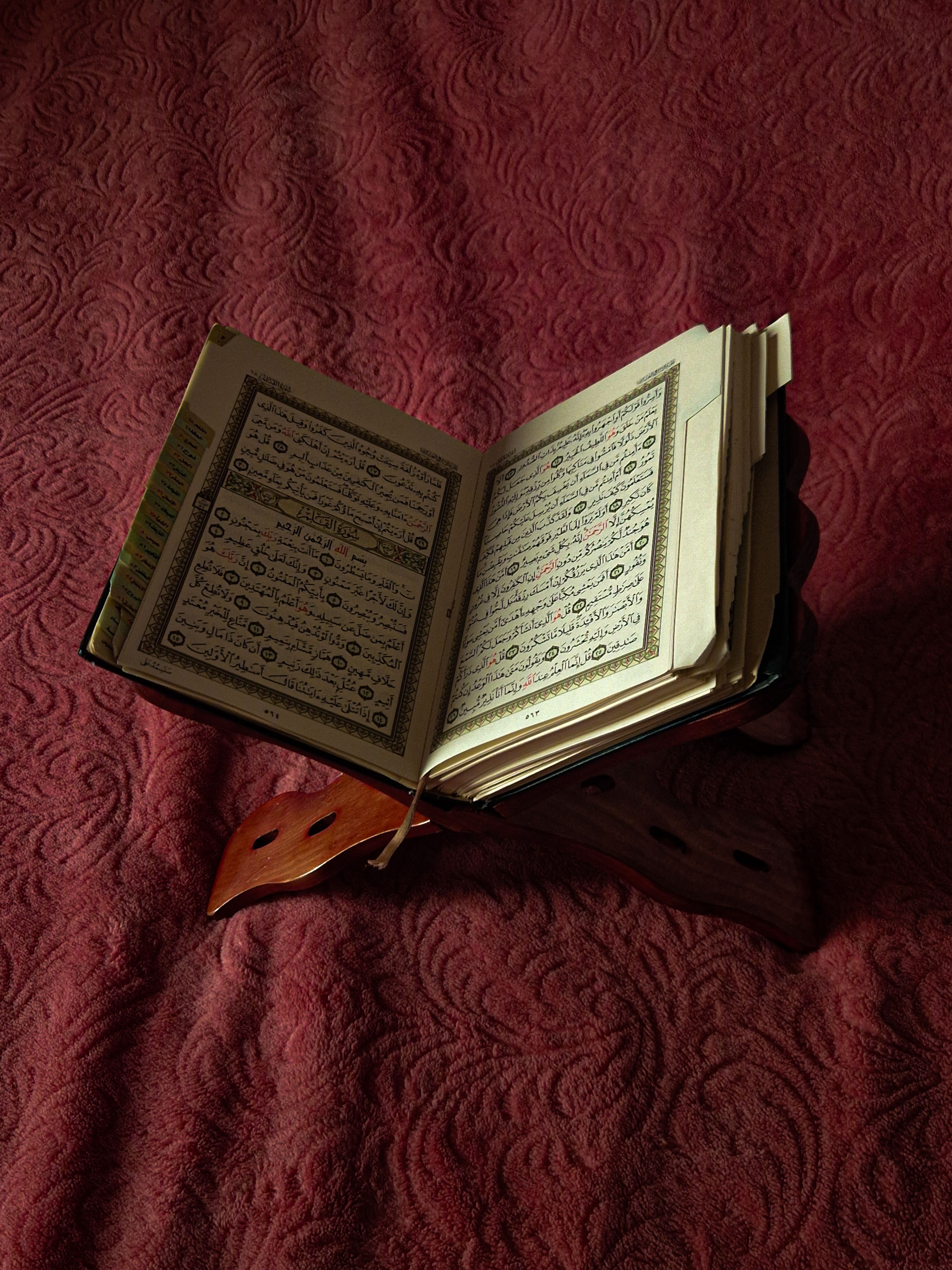 Open Quran on Wooden Stand in Dim Light · Free Stock Photo