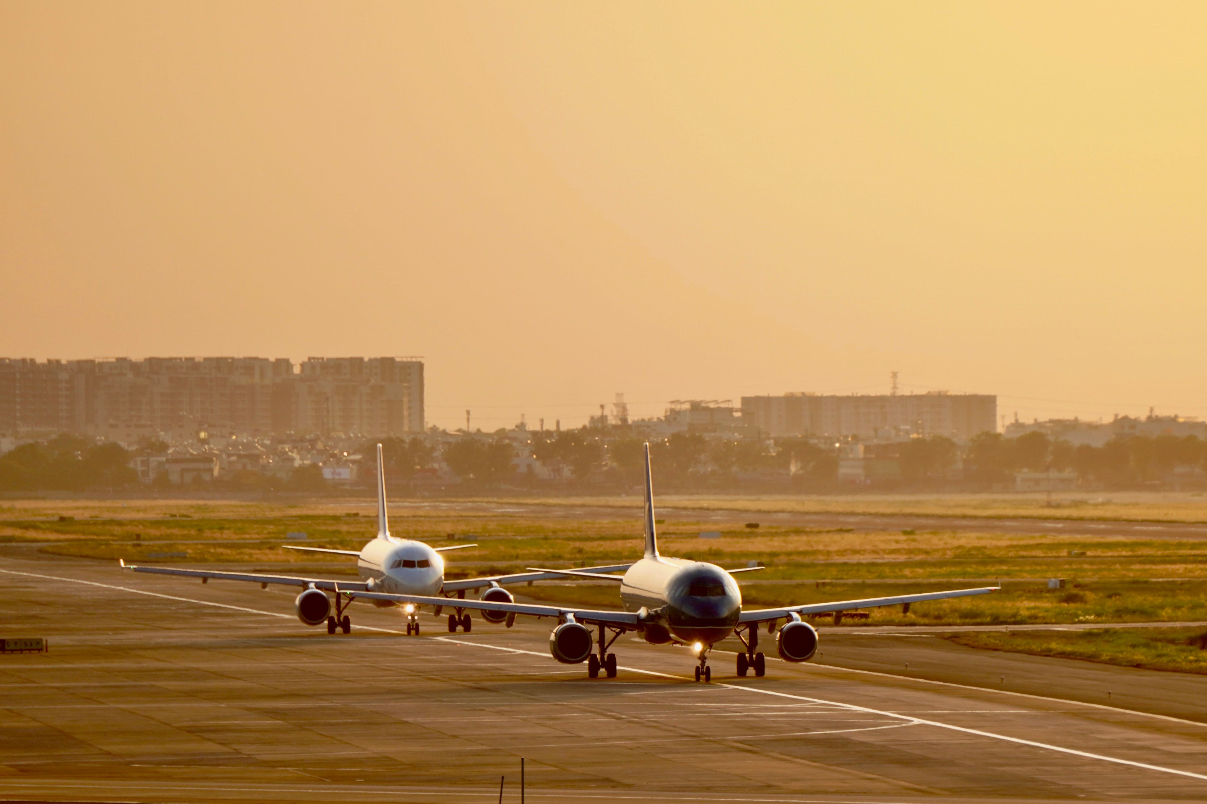 Airplanes Taxiing on Runway at Sunset · Free Stock Photo