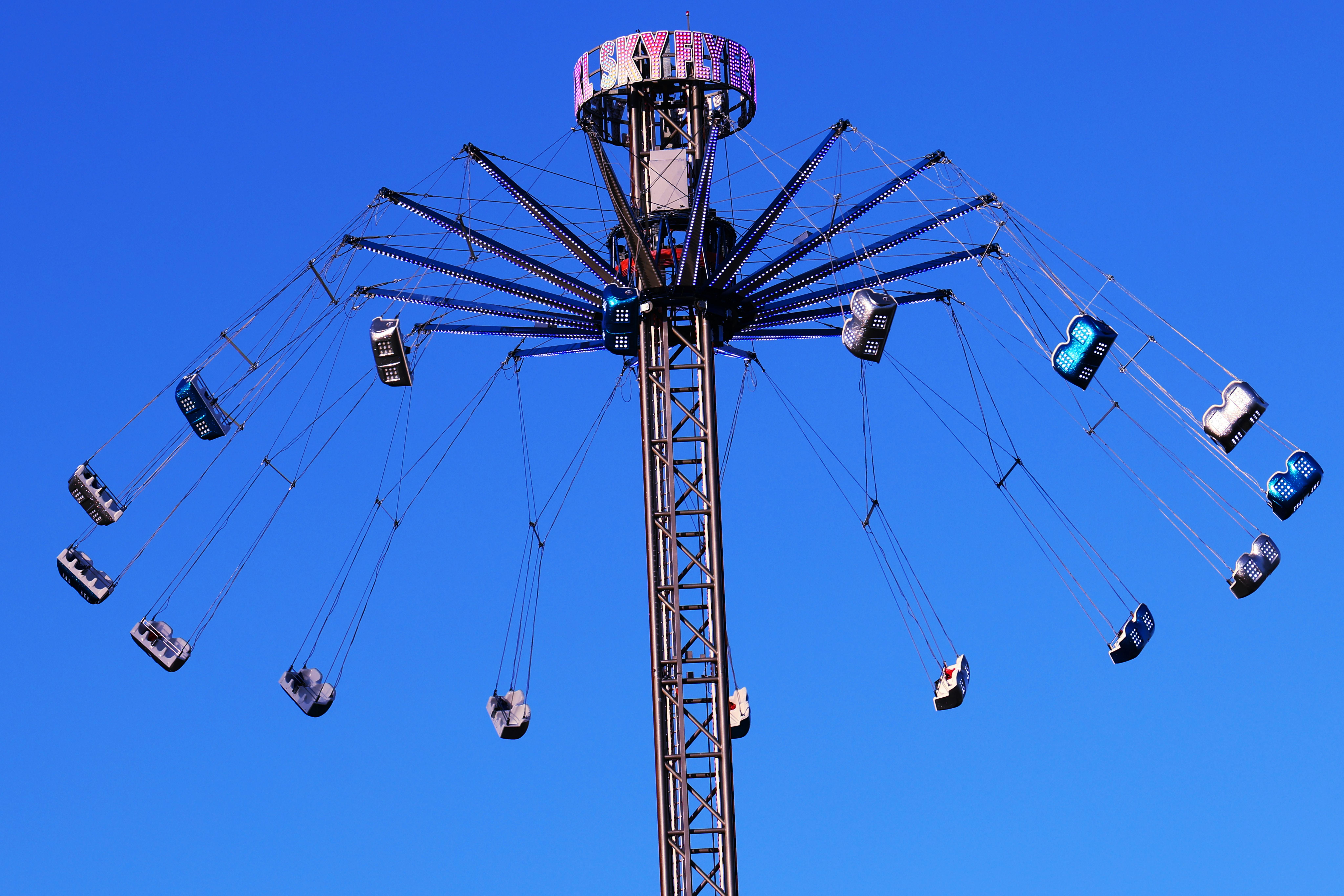 Sky Flyer Spinning Carnival Ride Against Blue Sky · Free Stock Photo