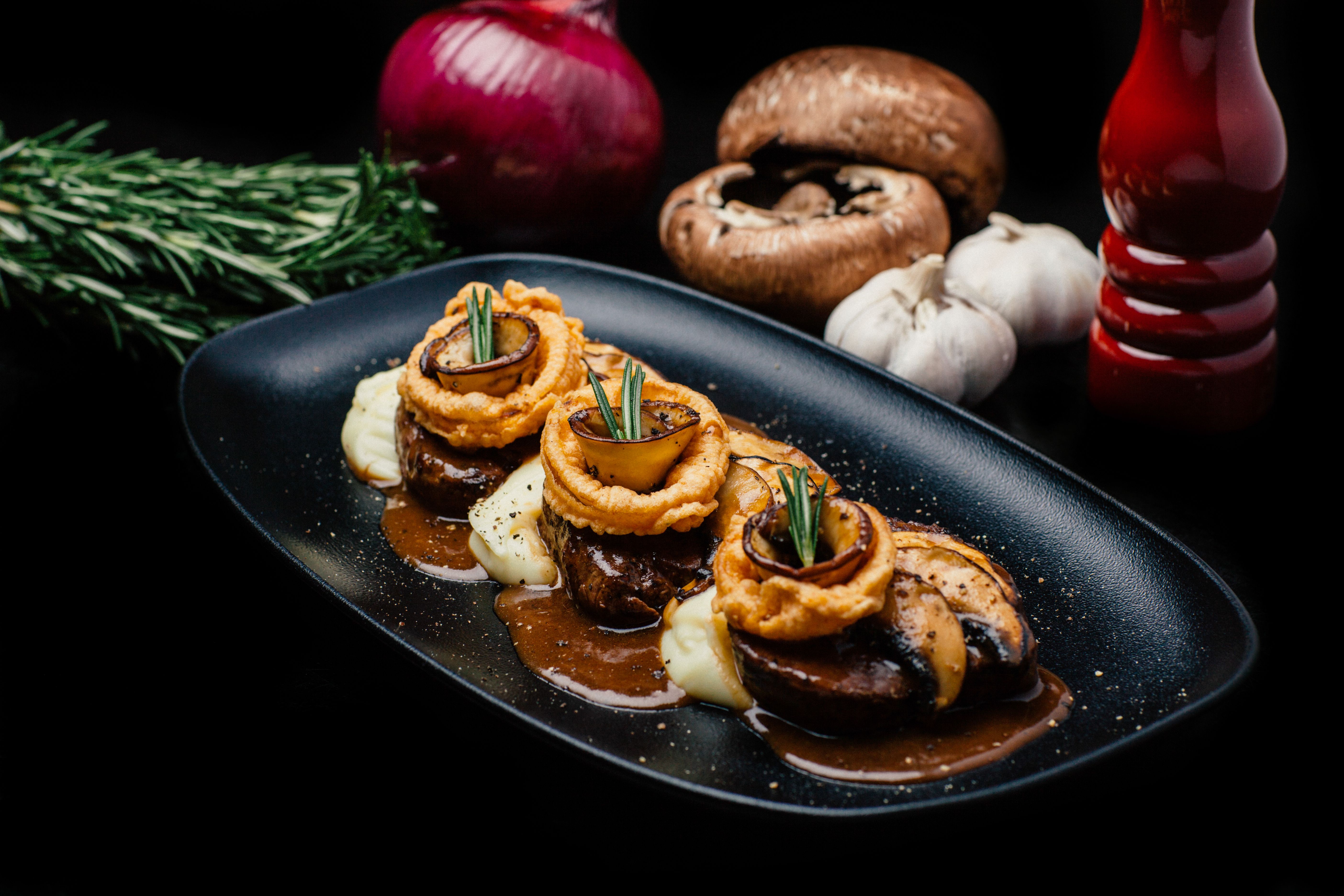 Plato Gourmet De Carne De Res Con Aros De Cebolla Y Champiñones · Foto ...