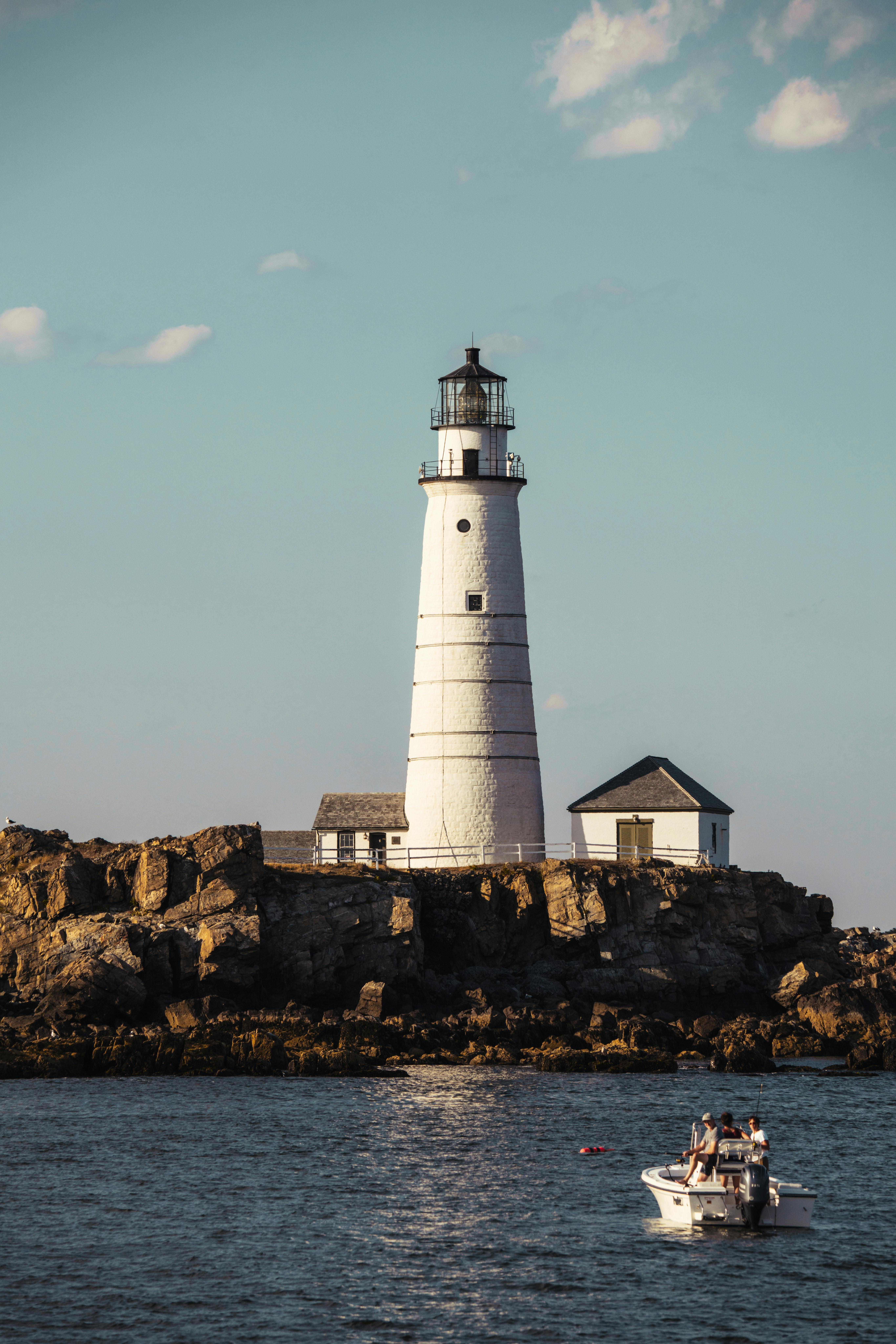 Boston Light Lighthouse with Boat at Sunset · Free Stock Photo
