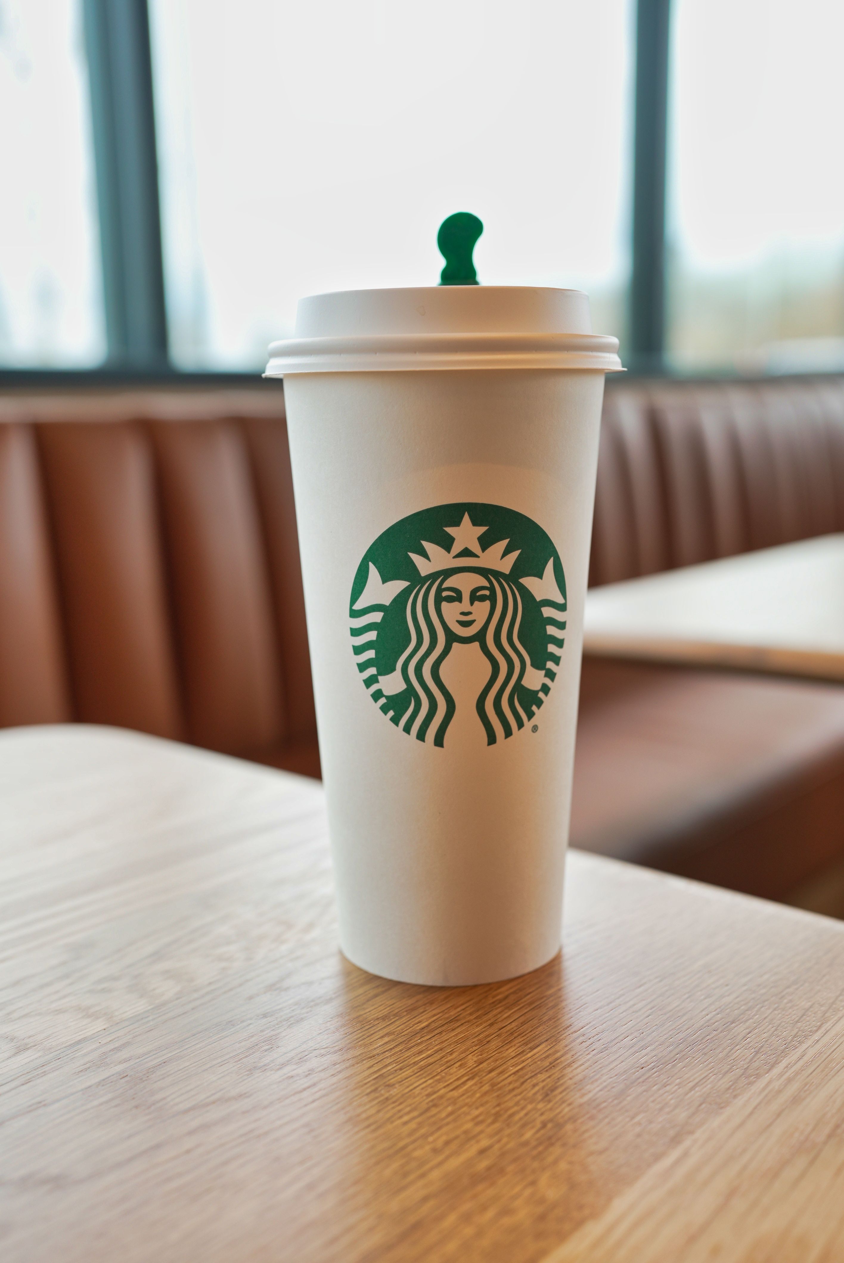 Tall Starbucks Coffee Cup on Wooden Table · Free Stock Photo