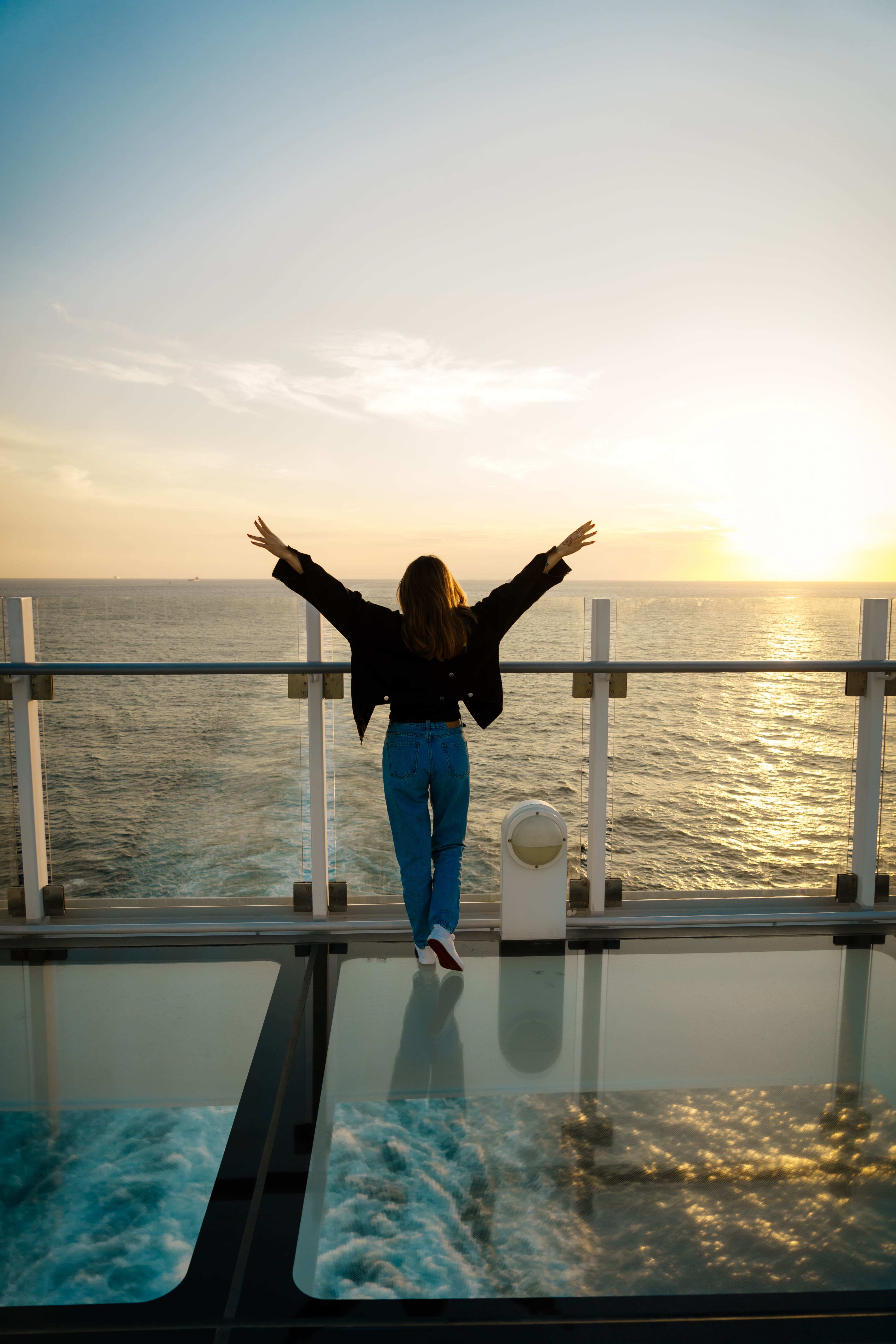 Person Embracing Sunset on Ocean Deck · Free Stock Photo