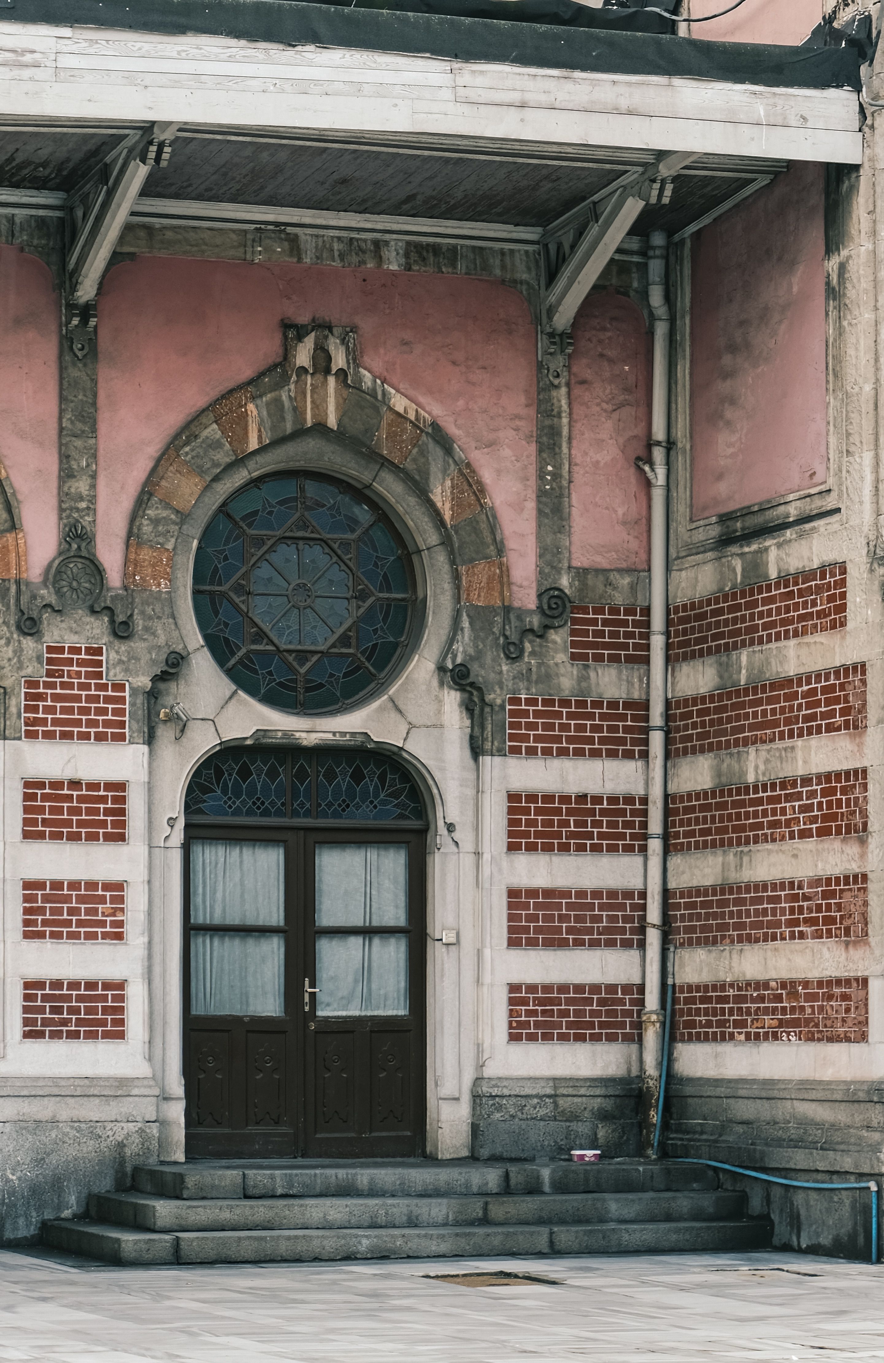 Historic Ornate Building Facade with Circular Window · Free Stock Photo