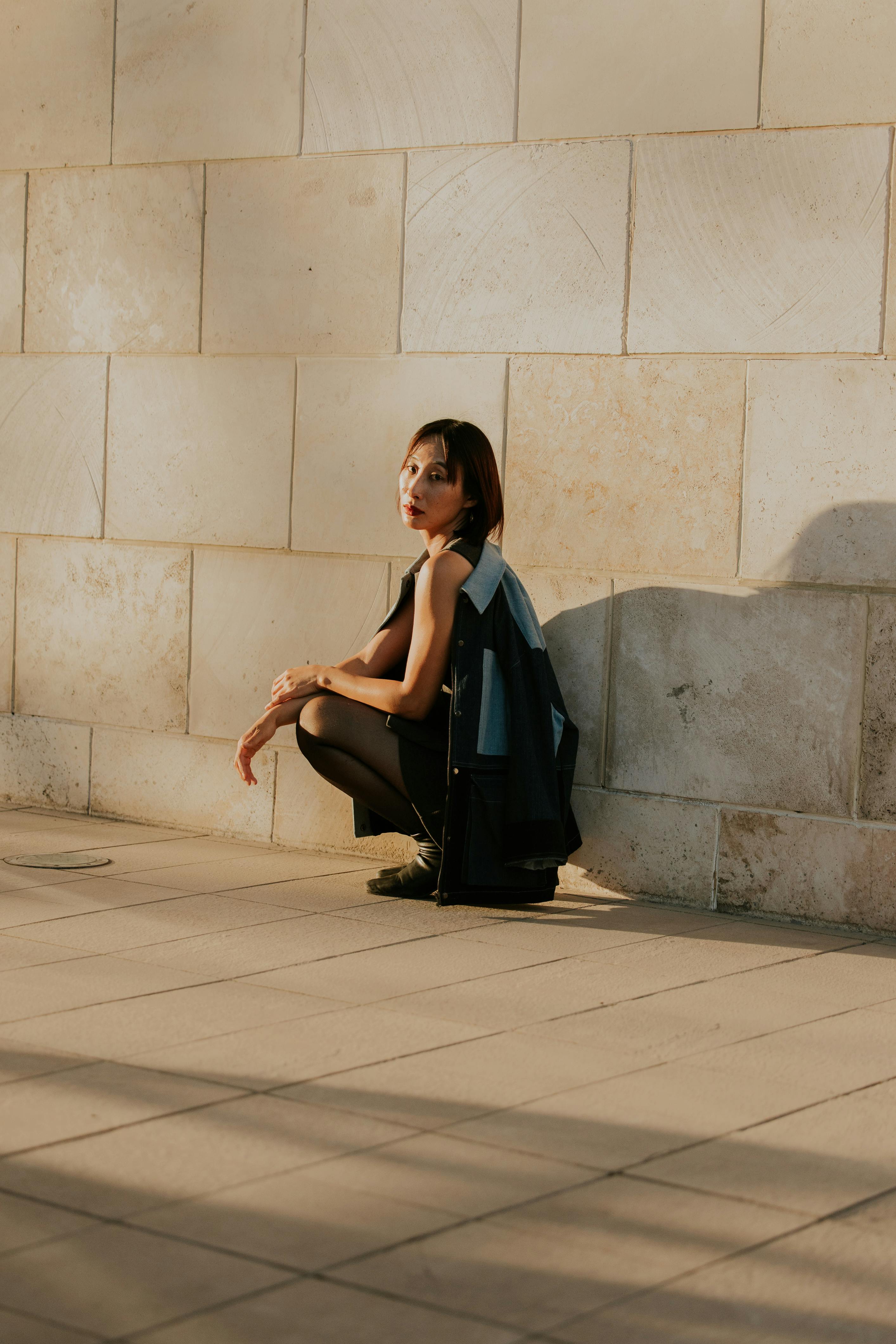Contemplative Woman in Sunlit Urban Setting · Free Stock Photo