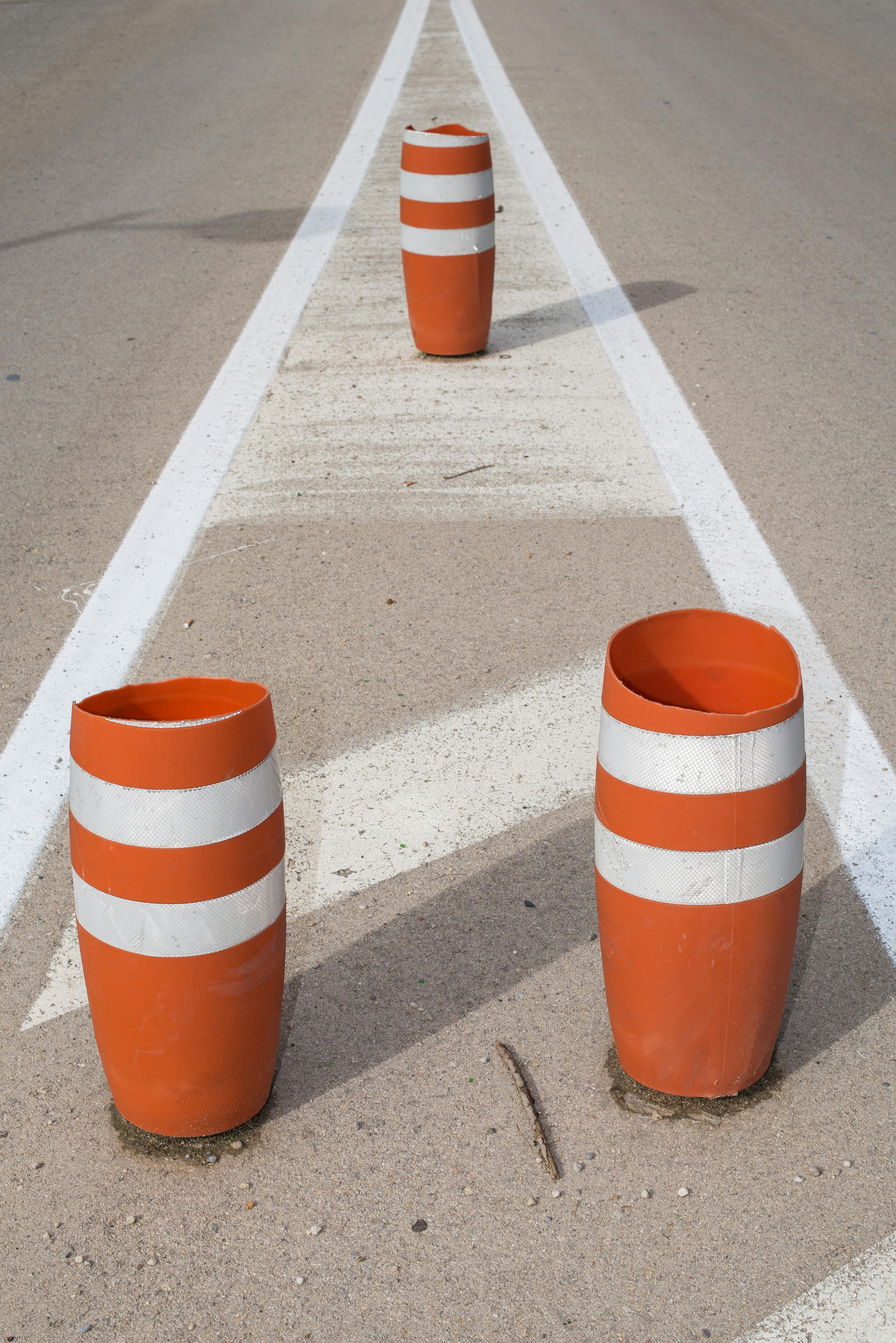 Orange Traffic Barrels on Asphalt Roadway · Free Stock Photo