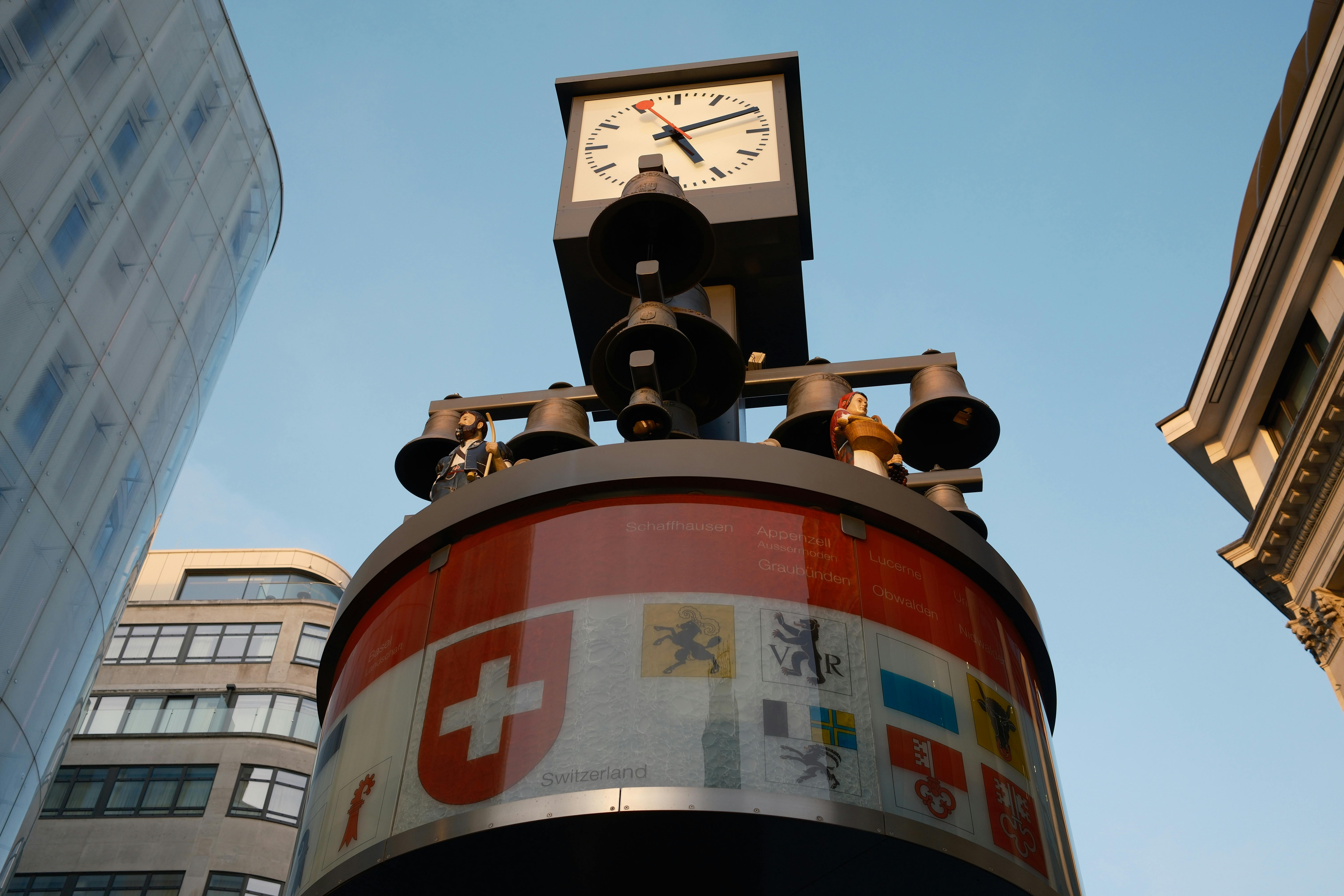 Colorful Swiss Clock Tower Amidst Modern Buildings · Free Stock Photo