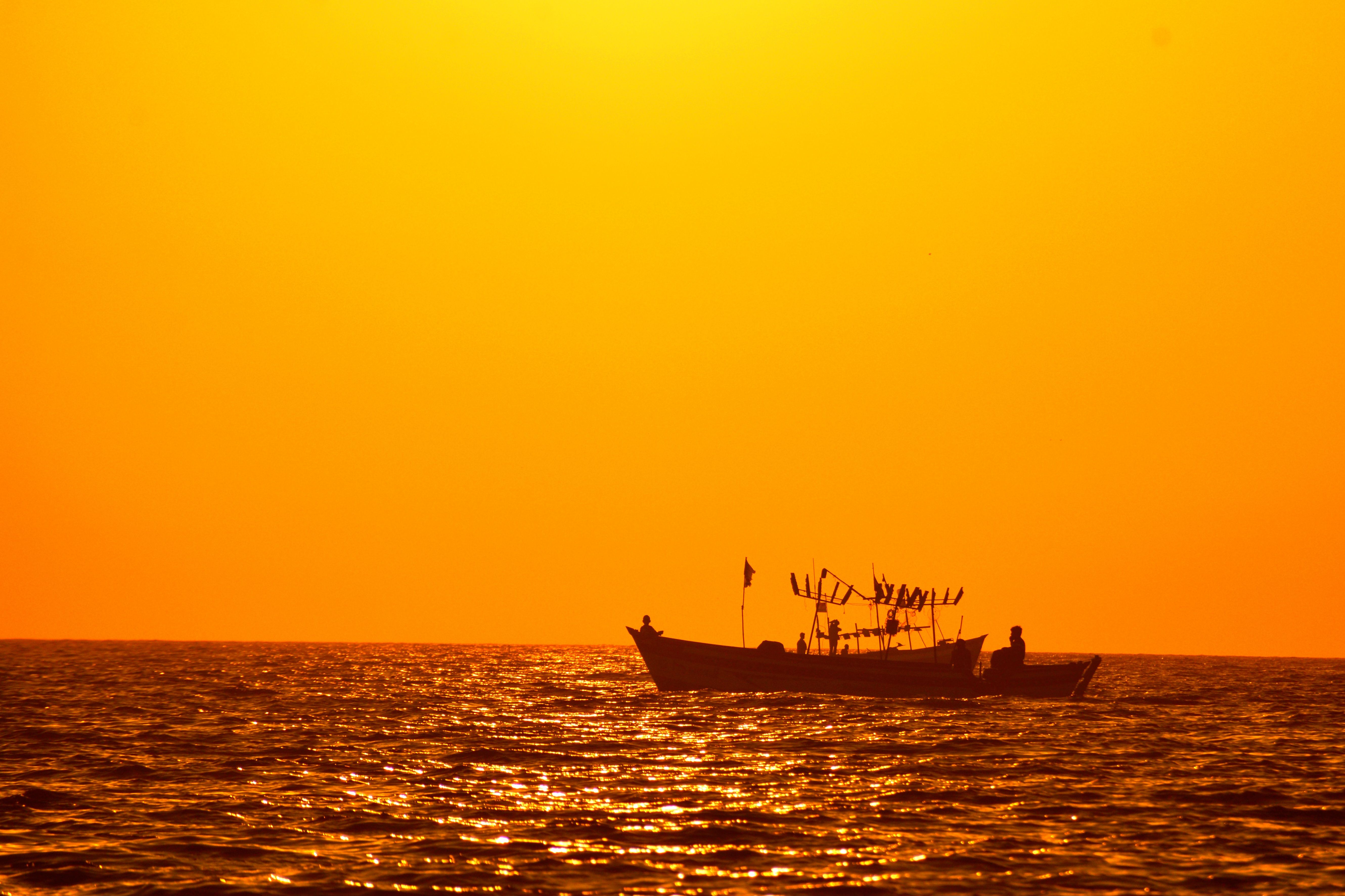 Golden Sunset over Dwarka with Silhouette Boat · Free Stock Photo