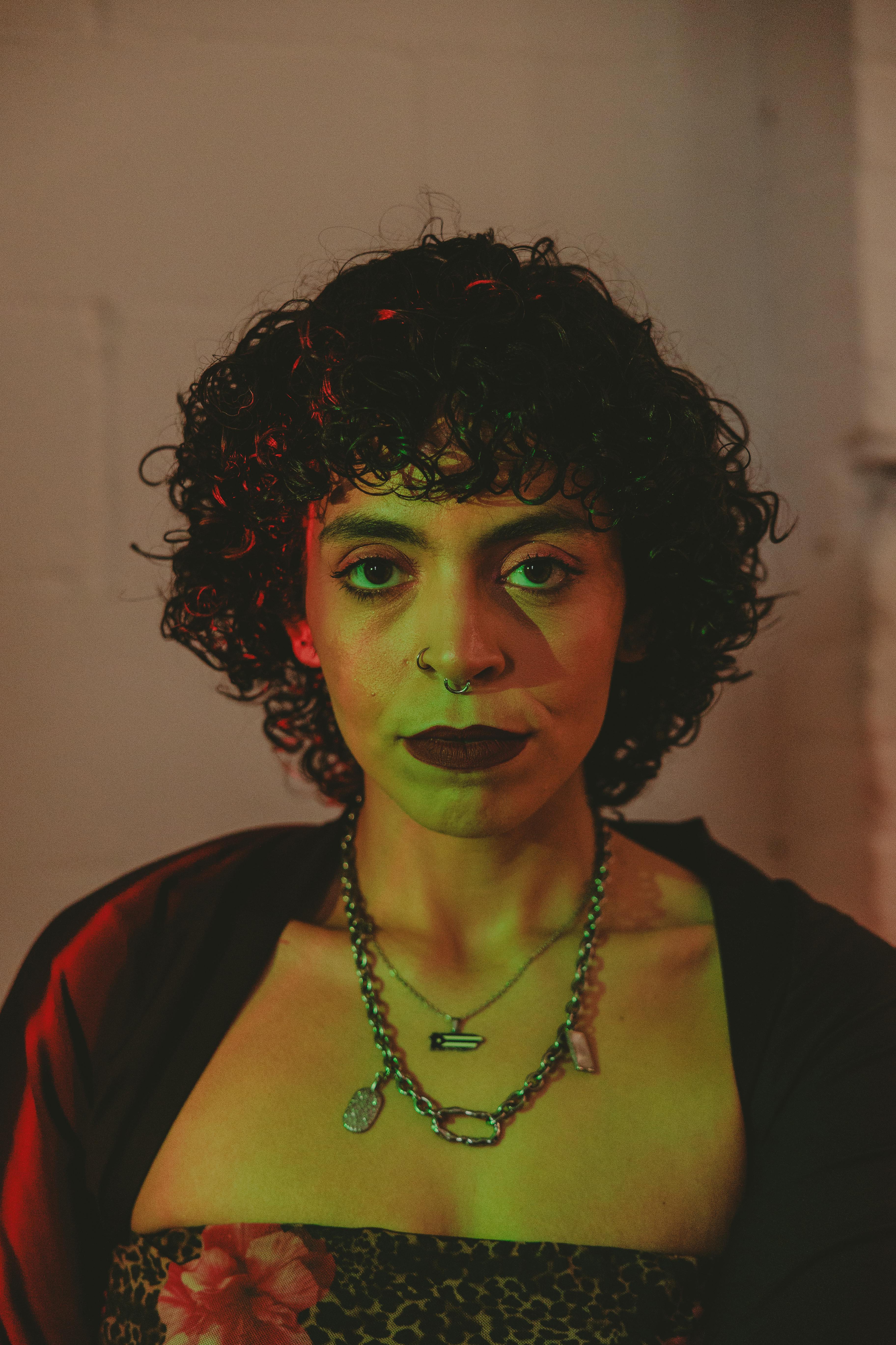 Moody Portrait with Intense Stare and Curly Hairstyle · Free Stock Photo