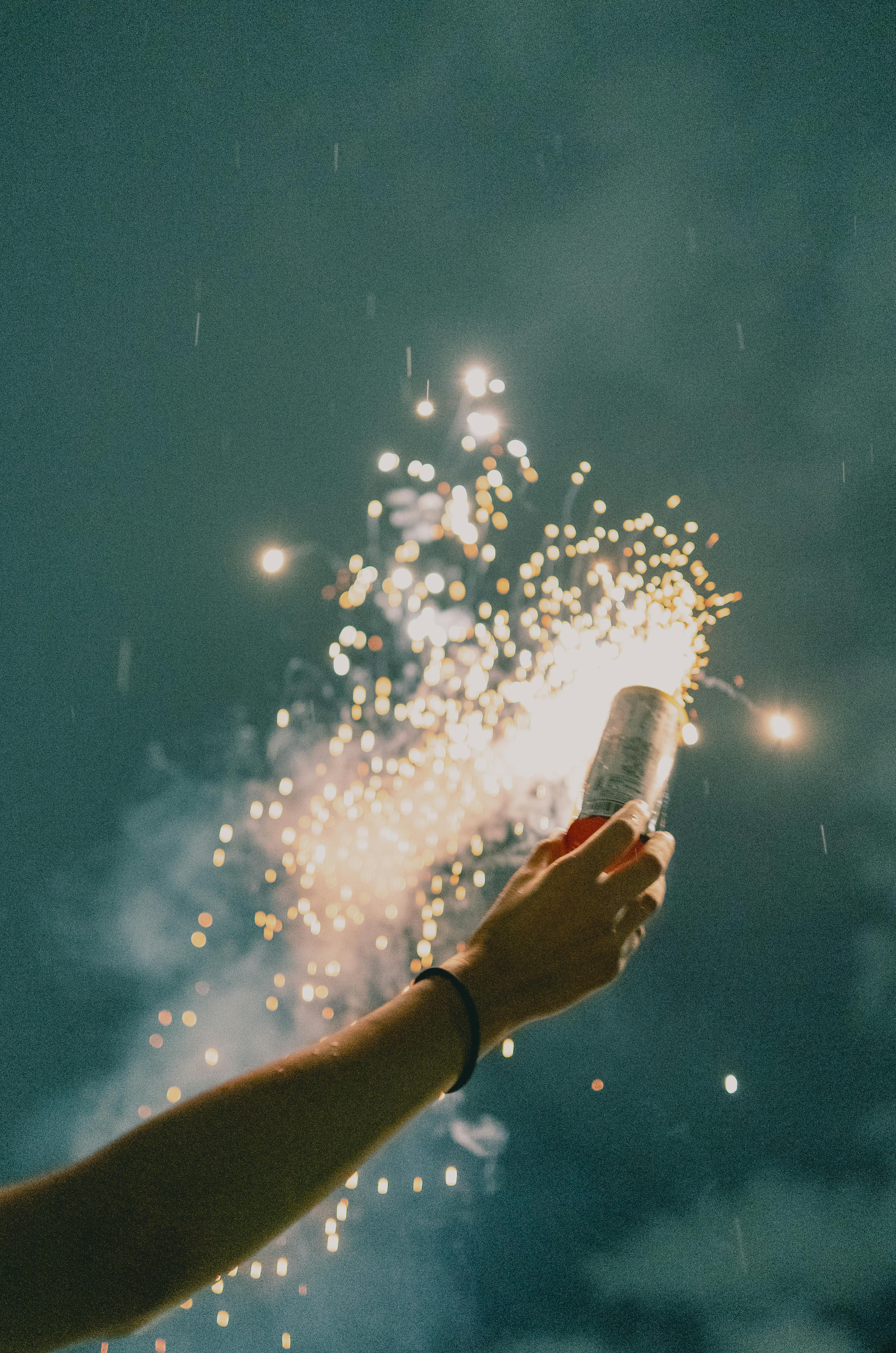 手持庆祝烟花在夜空中绽放 · 免费素材图片