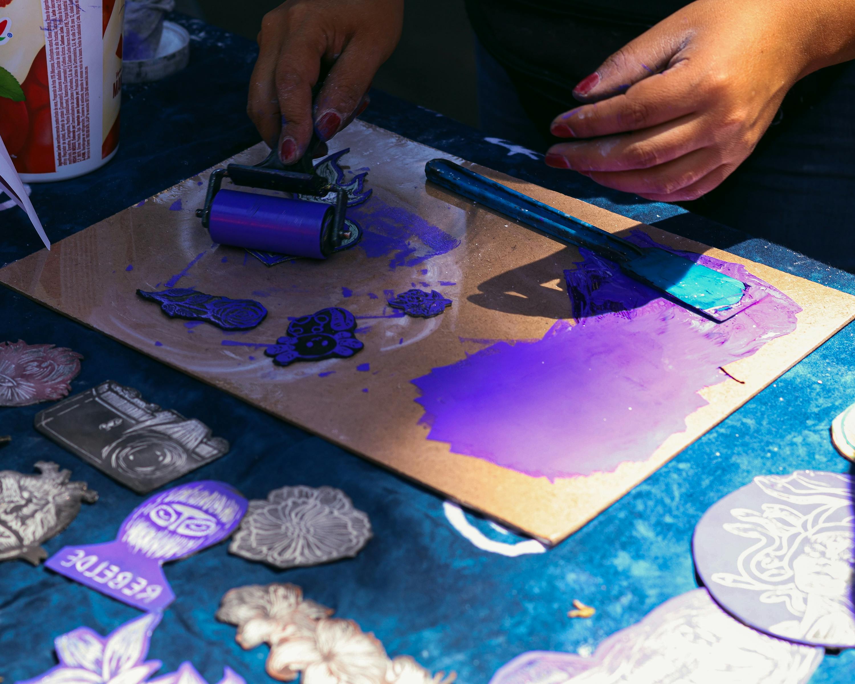 Hands Creating Vibrant Linocut Art Prints Outdoors · Free Stock Photo