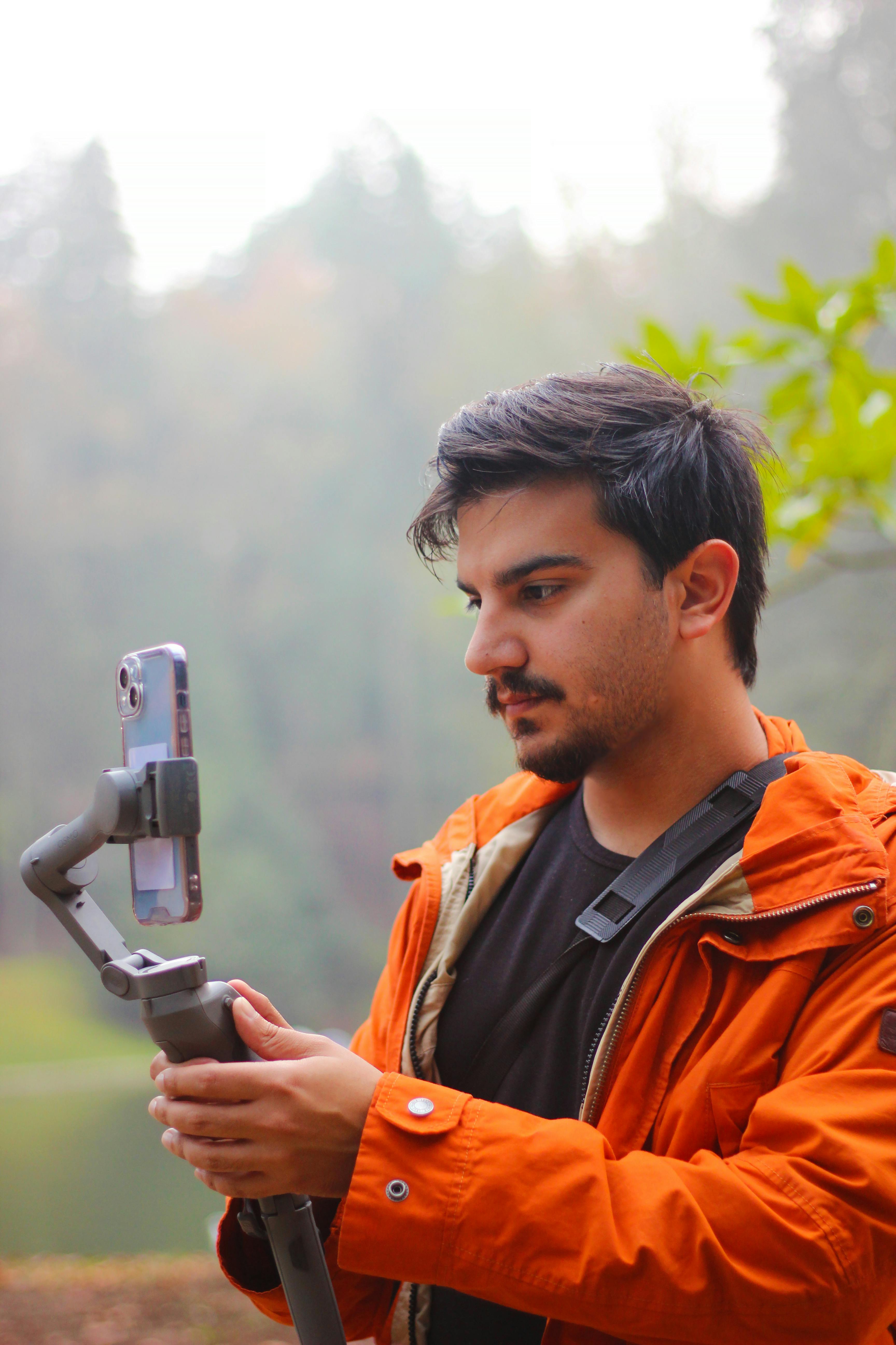 Young Man Filmmaker Using Gimbal Outdoors · Free Stock Photo