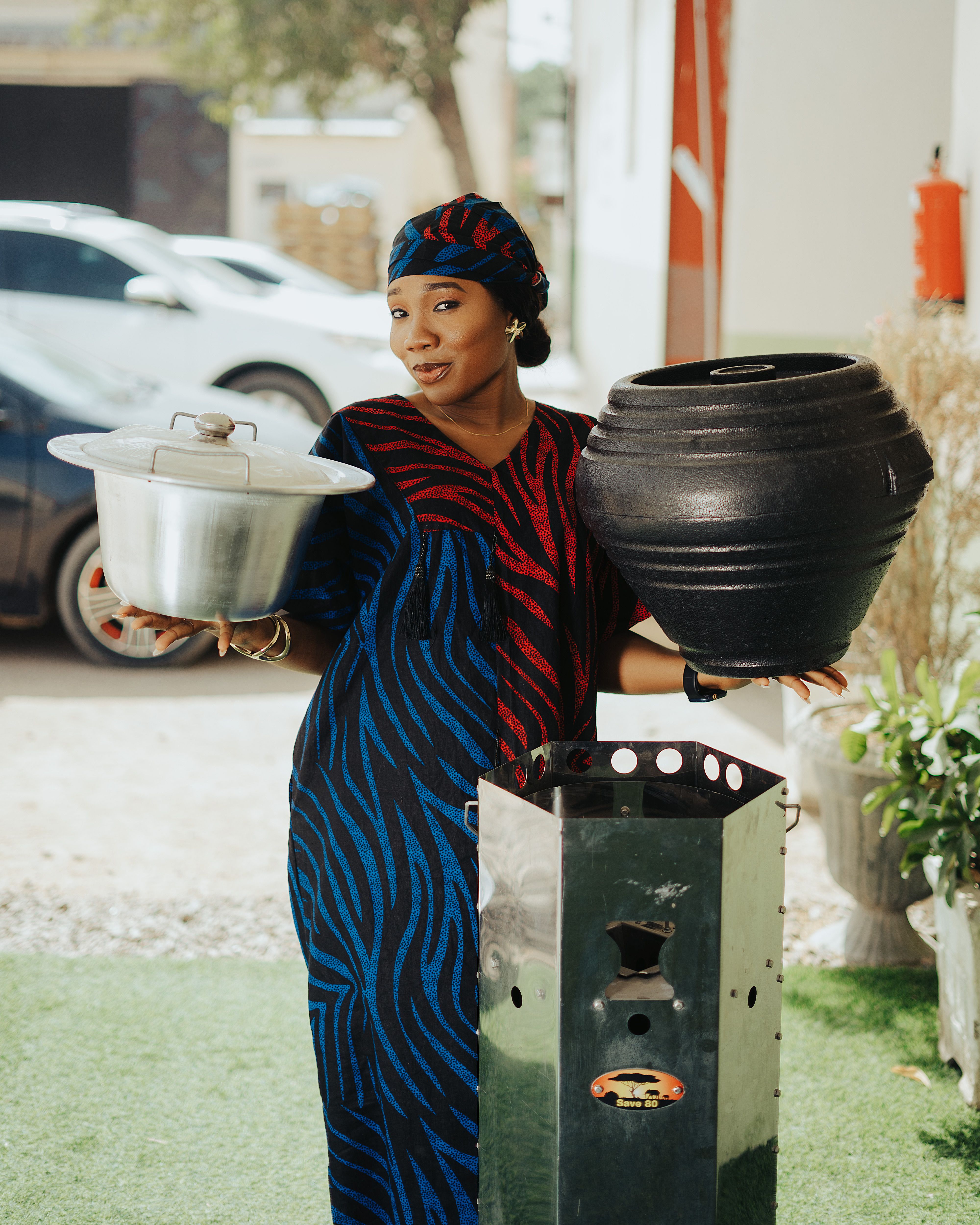 African woman holding cooking pots outdoors · Free Stock Photo
