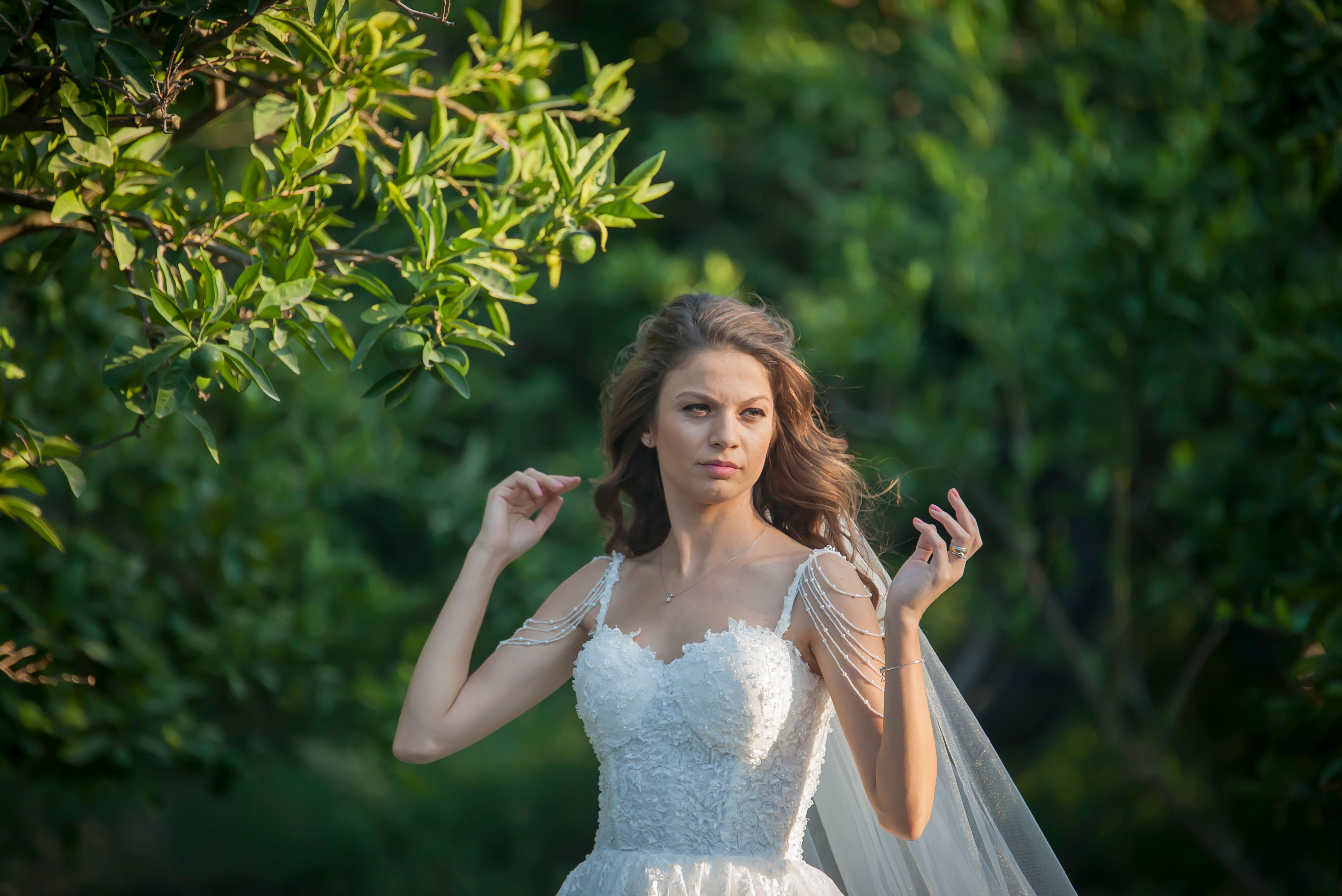 Bride Posing in Lush Green Outdoor Setting · Free Stock Photo