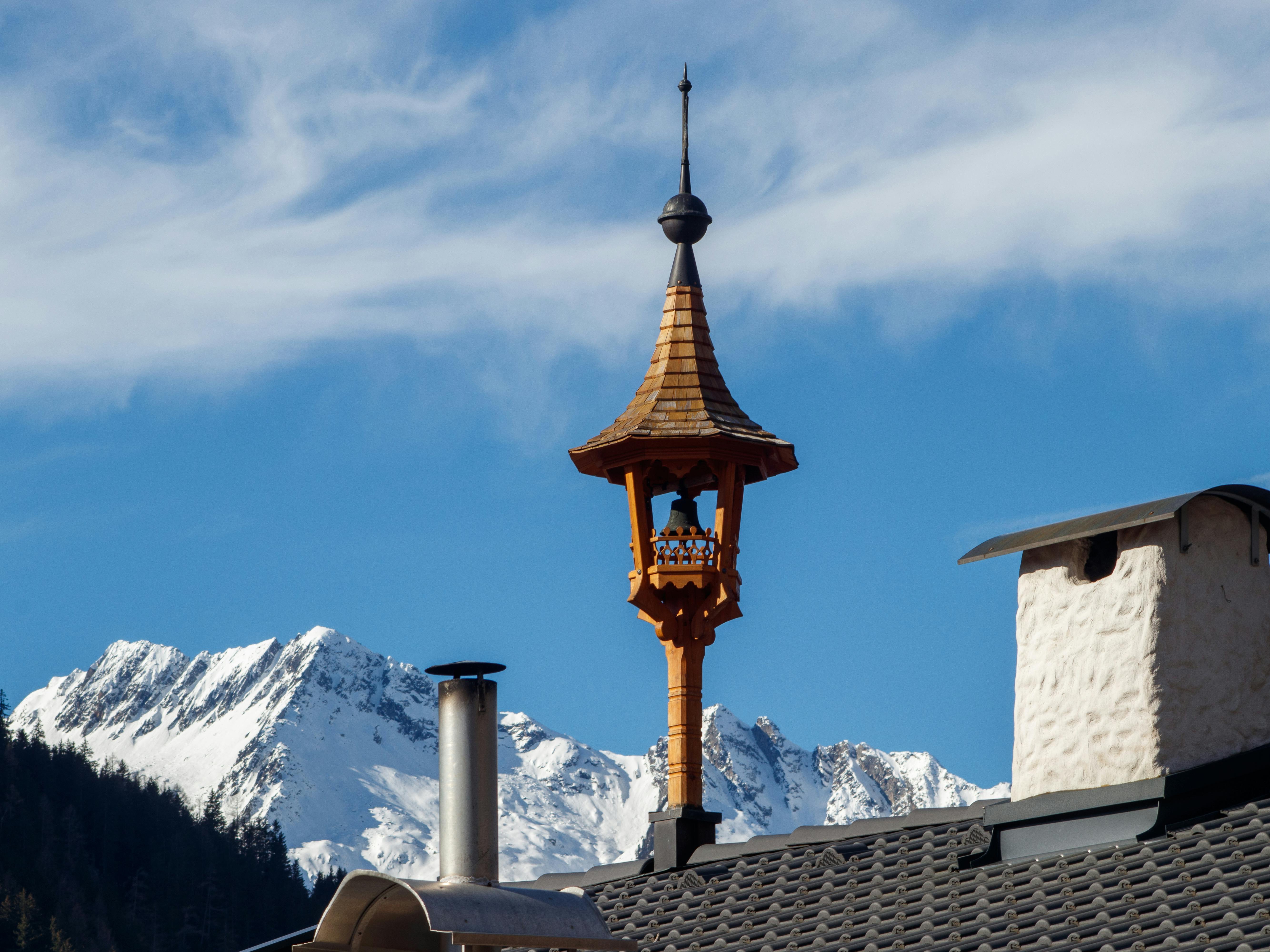 Charming Alpine Rooftop Against Snowy Peaks · Free Stock Photo
