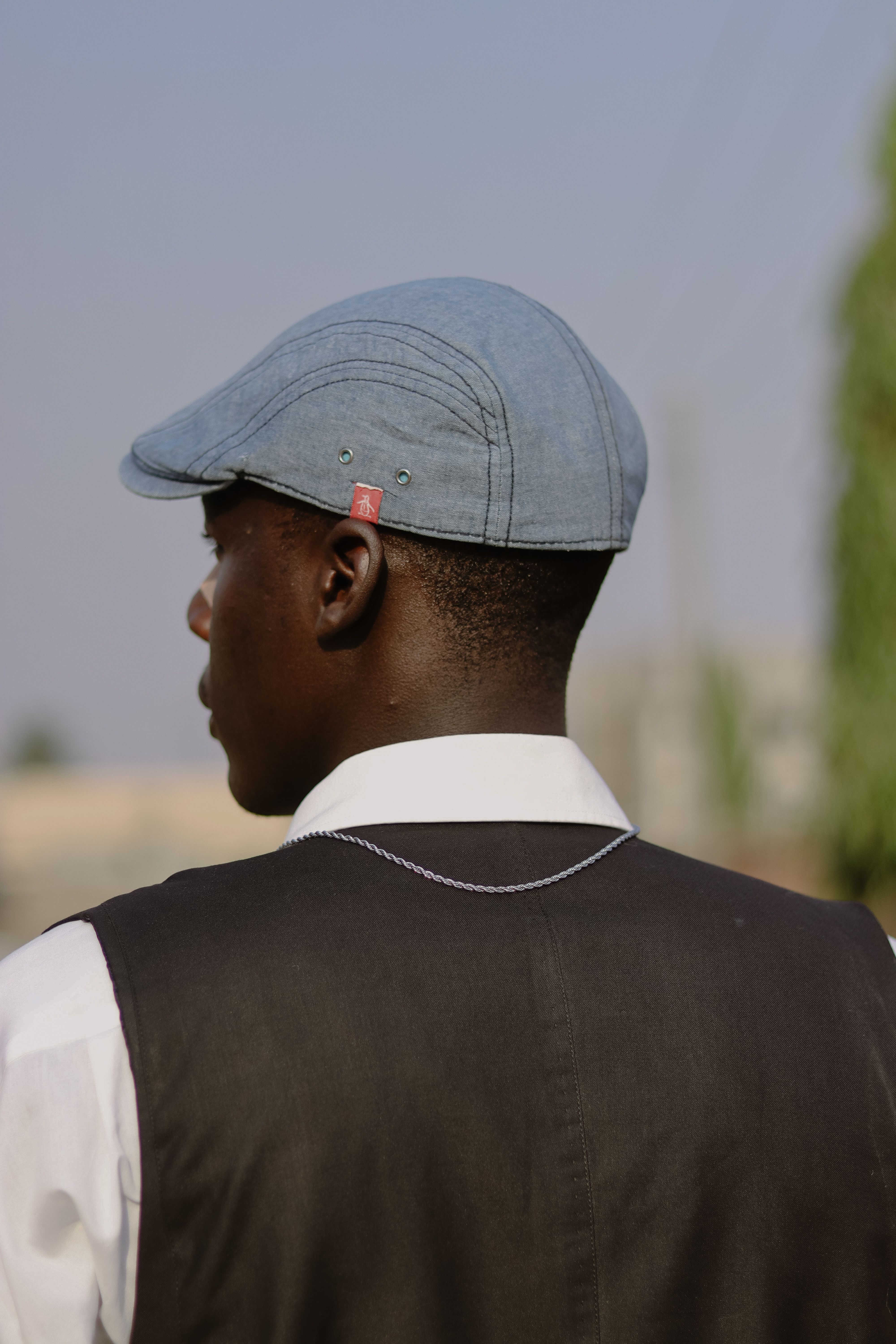 Profile Portrait of Man in Flat Cap Outdoors · Free Stock Photo