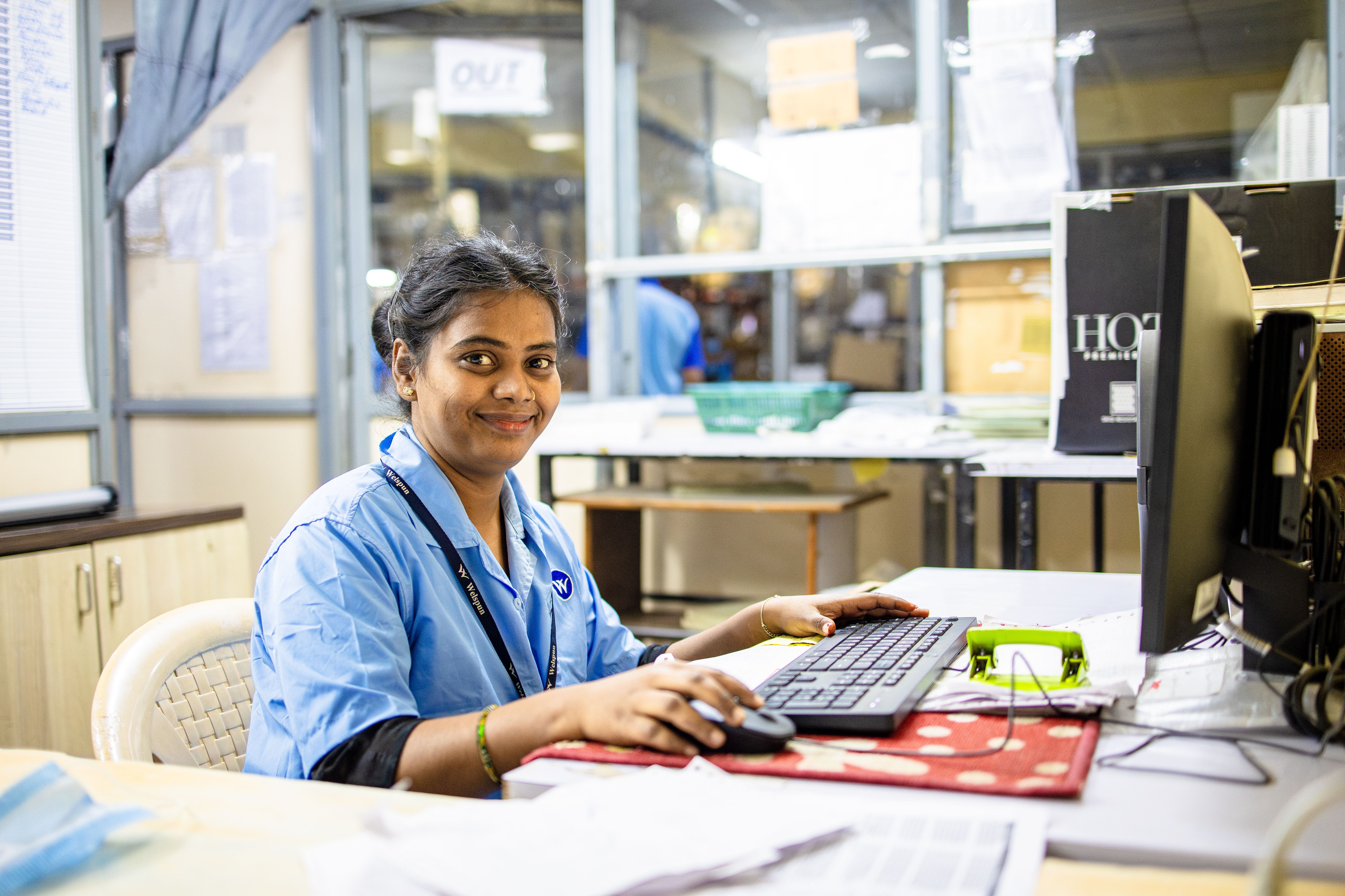 Smiling Office Worker at Desk in Modern Workplace · Free Stock Photo