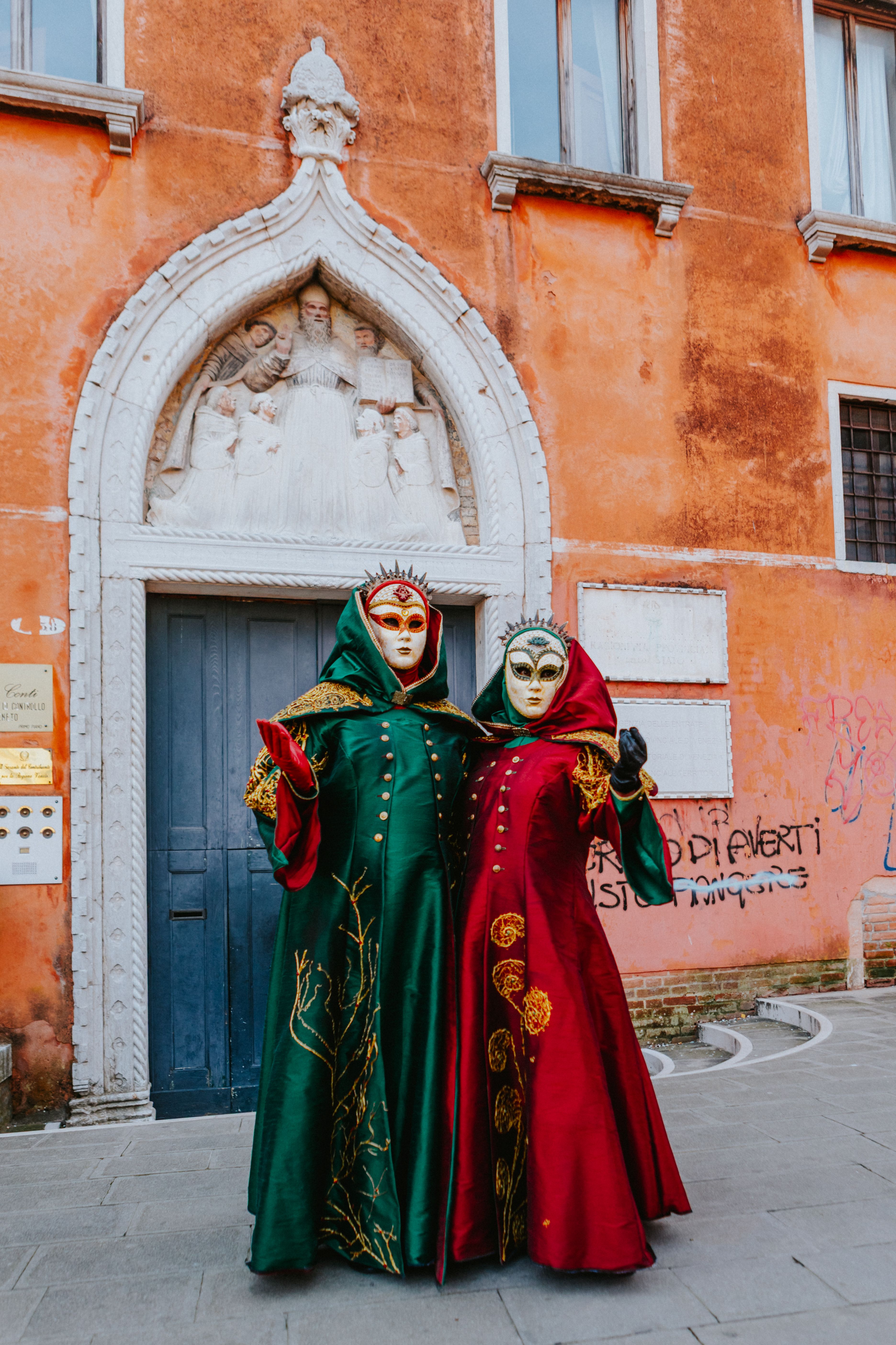 Venetian Masked Costumes in Vibrant Attire Outdoors · Free Stock Photo