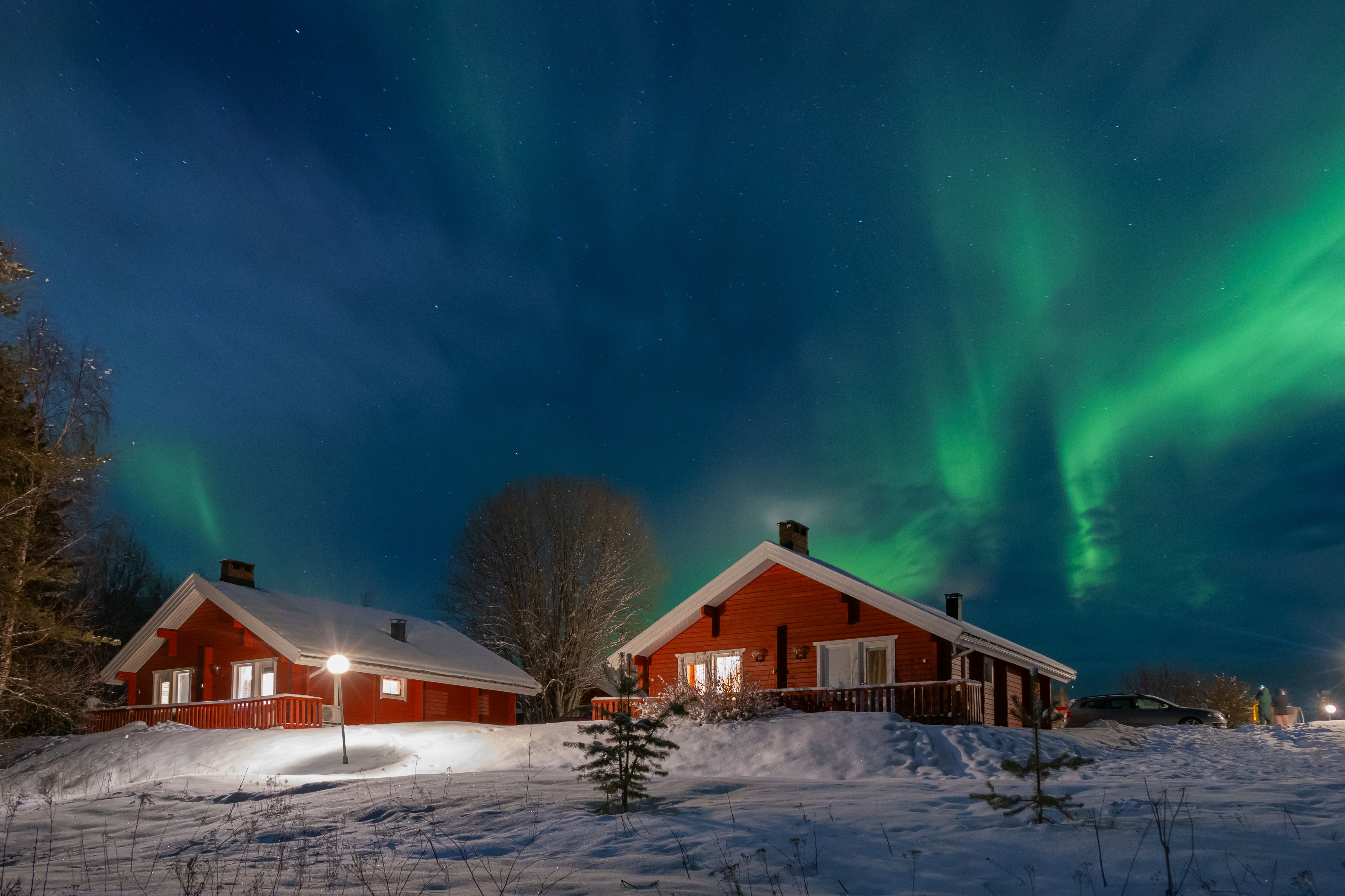 Stunning Northern Lights Over Finnish Cabins · Free Stock Photo
