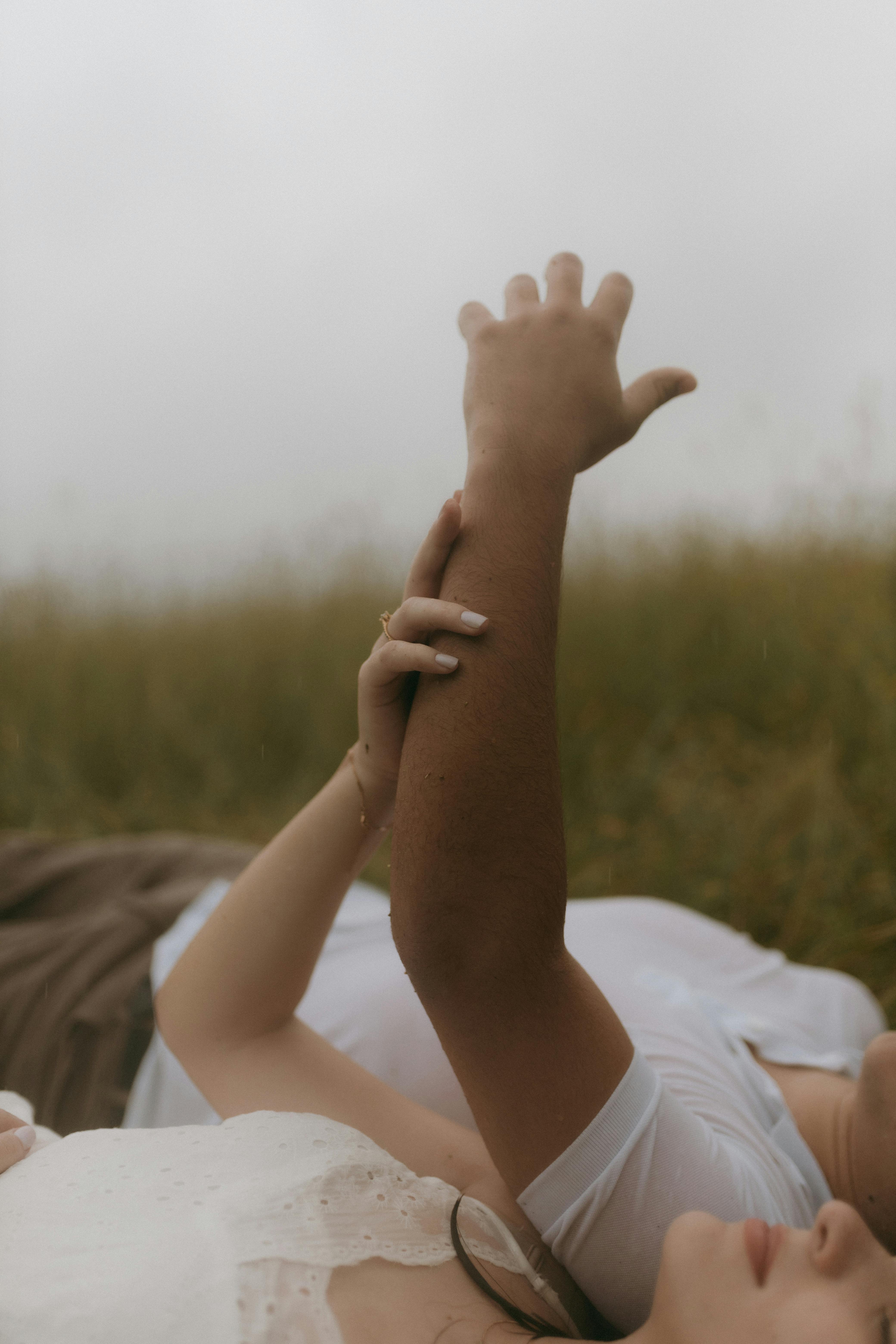 Intertwined Arms in a Serene Outdoor Setting · Free Stock Photo